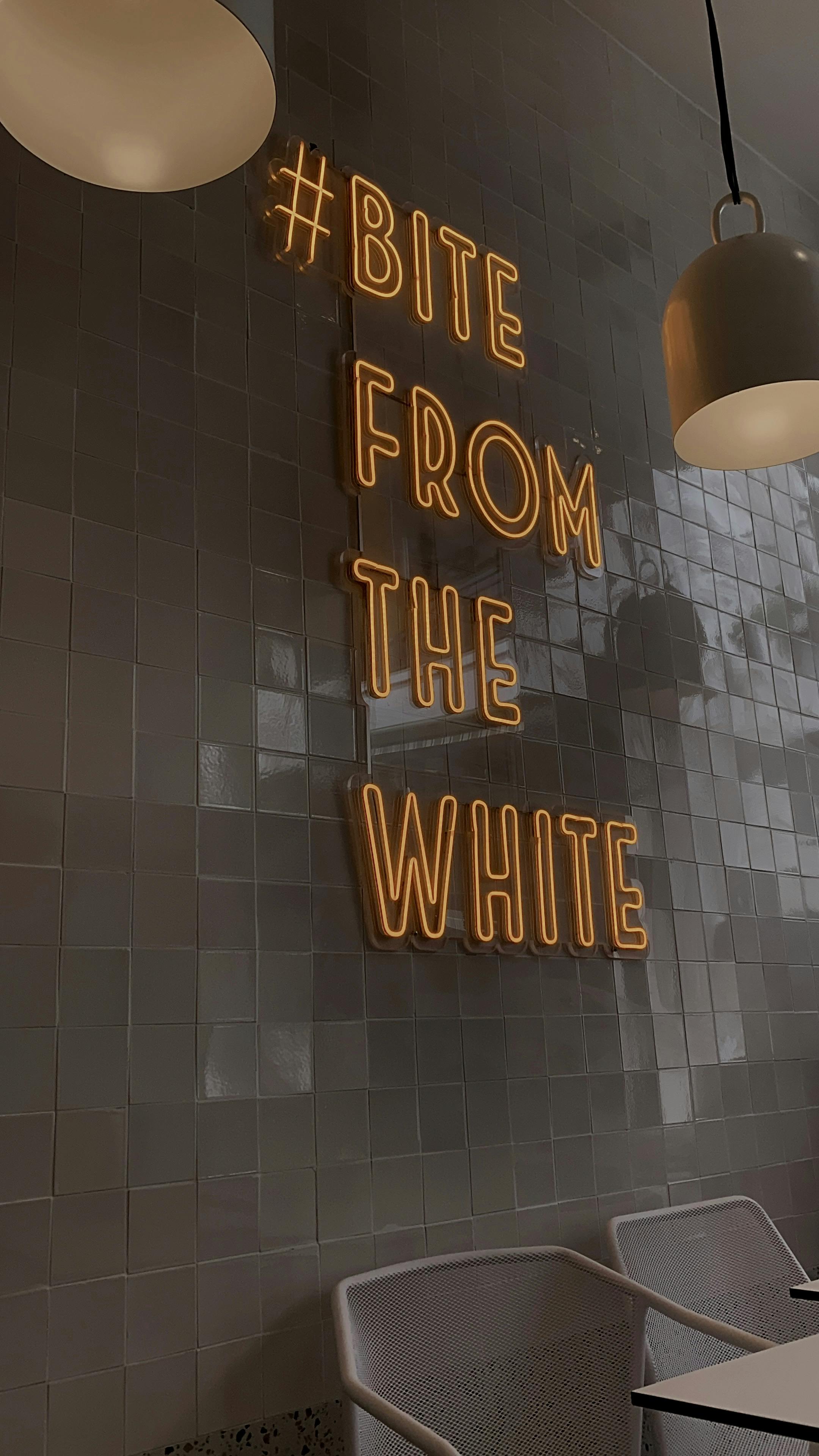 A neon sign that says bite from the white · Free Stock Photo