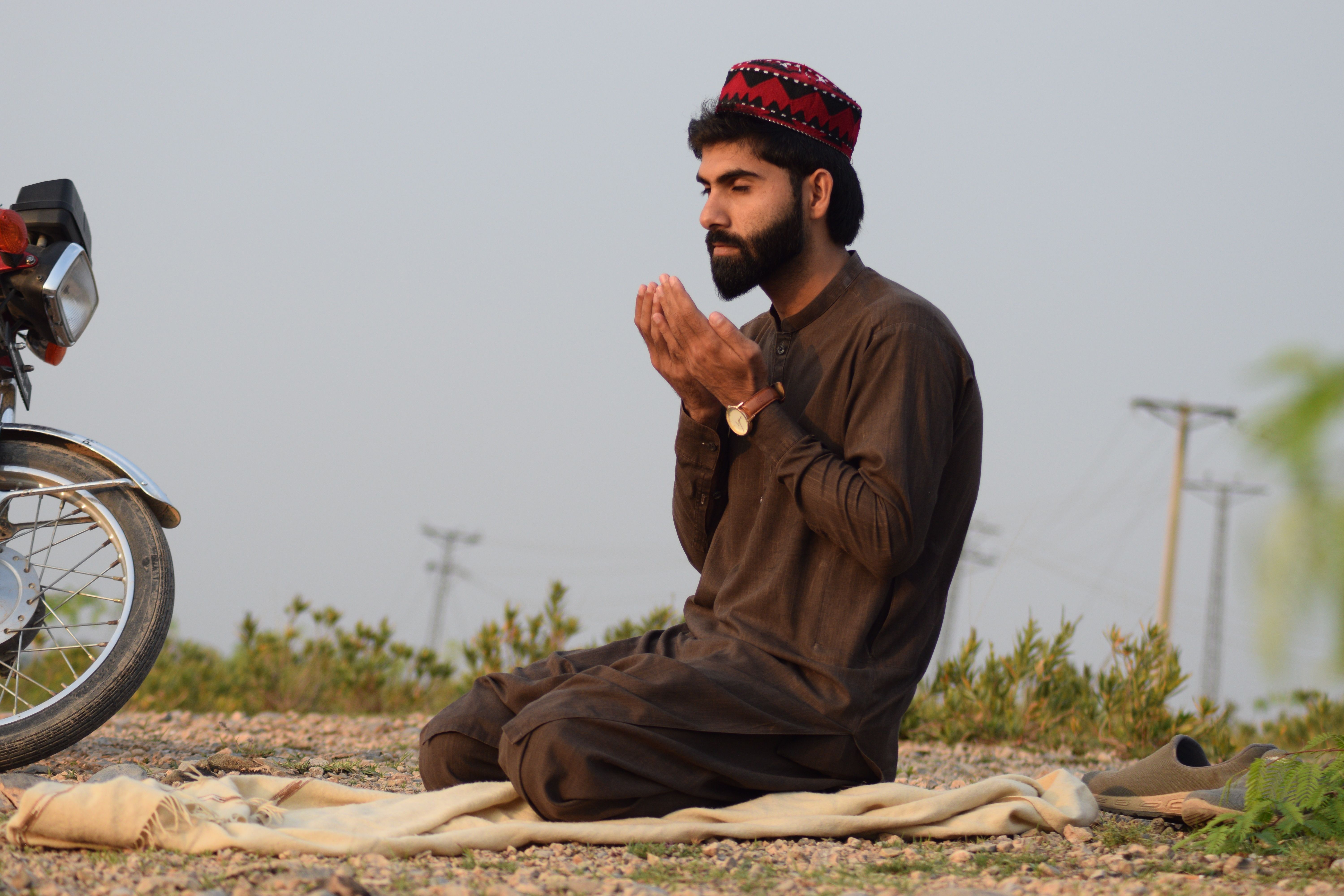 Man Sitting on Ground and Praying · Free Stock Photo