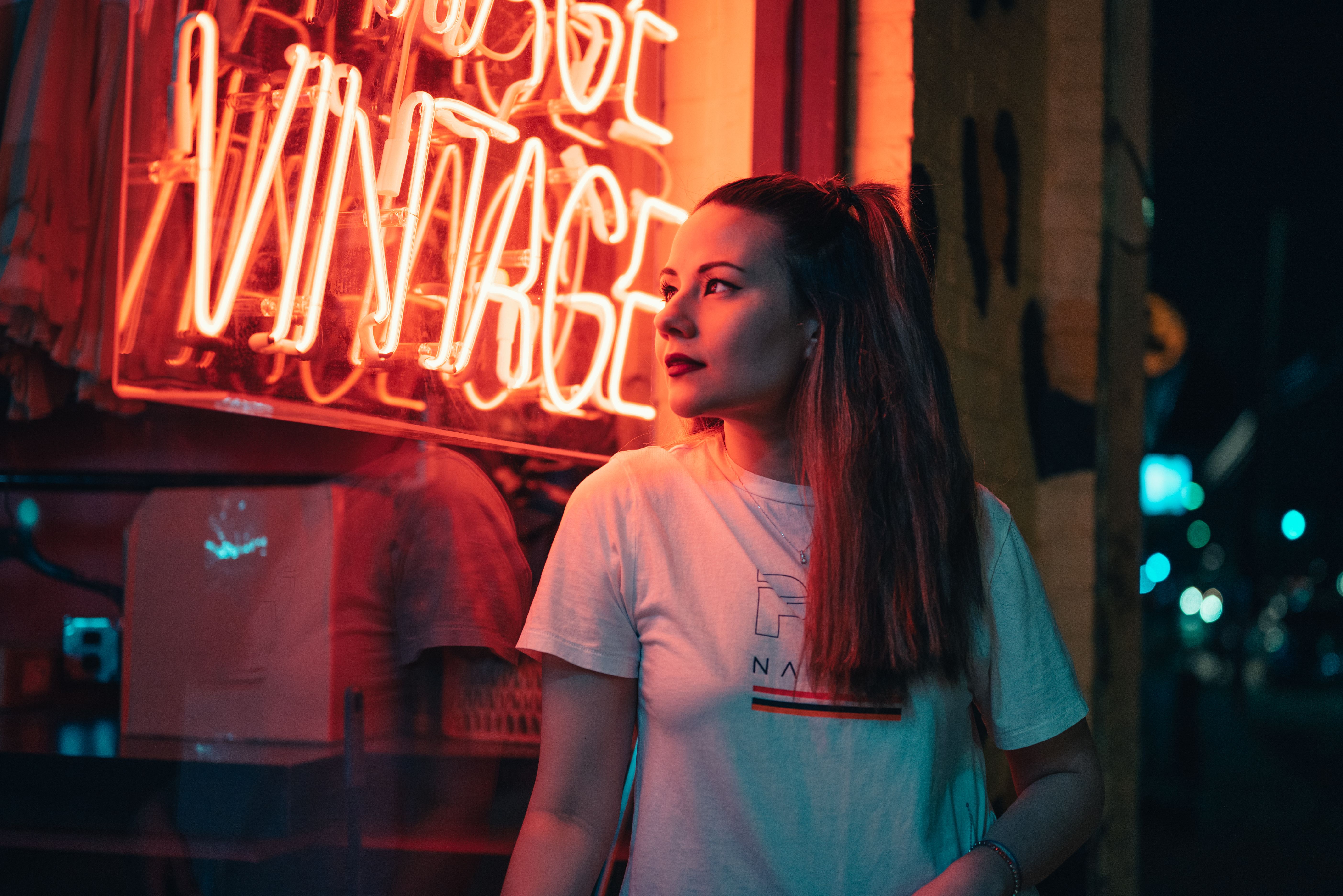 A woman standing in front of a neon sign · Free Stock Photo
