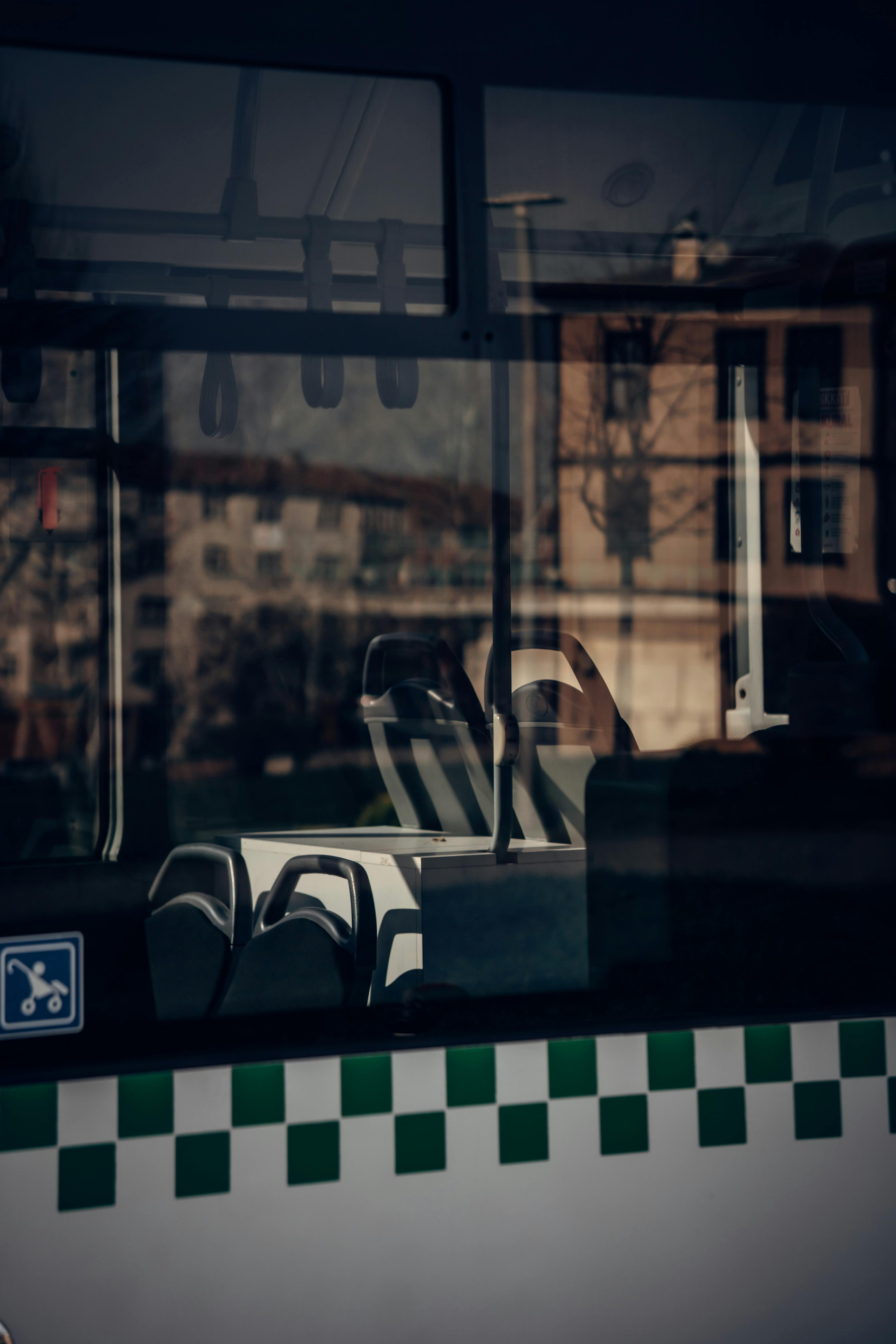 Empty Bus and a Reflection of Buildings in the Window · Free Stock Photo