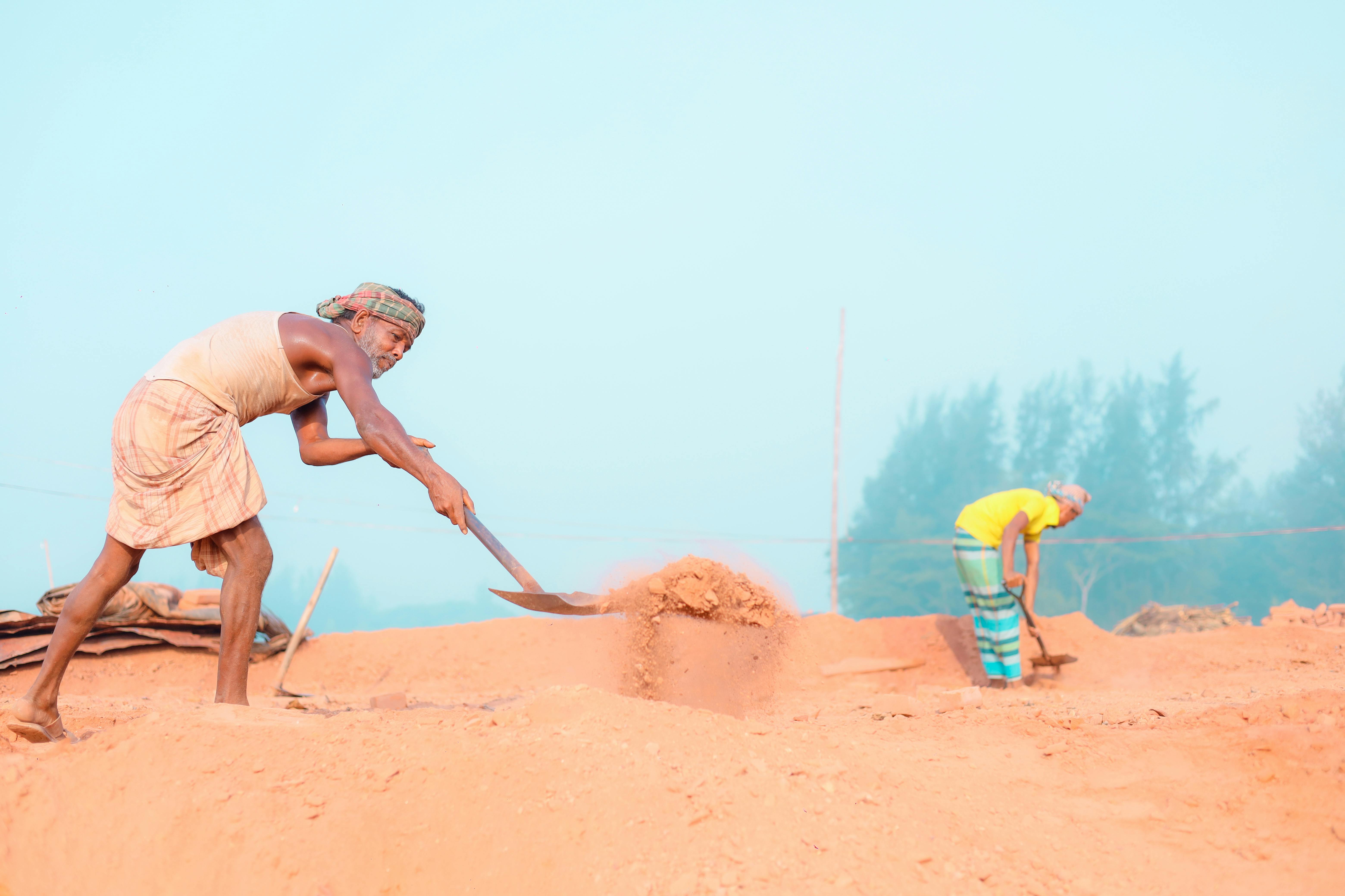 Male Worker Pulling a Garbage Bin · Free Stock Photo