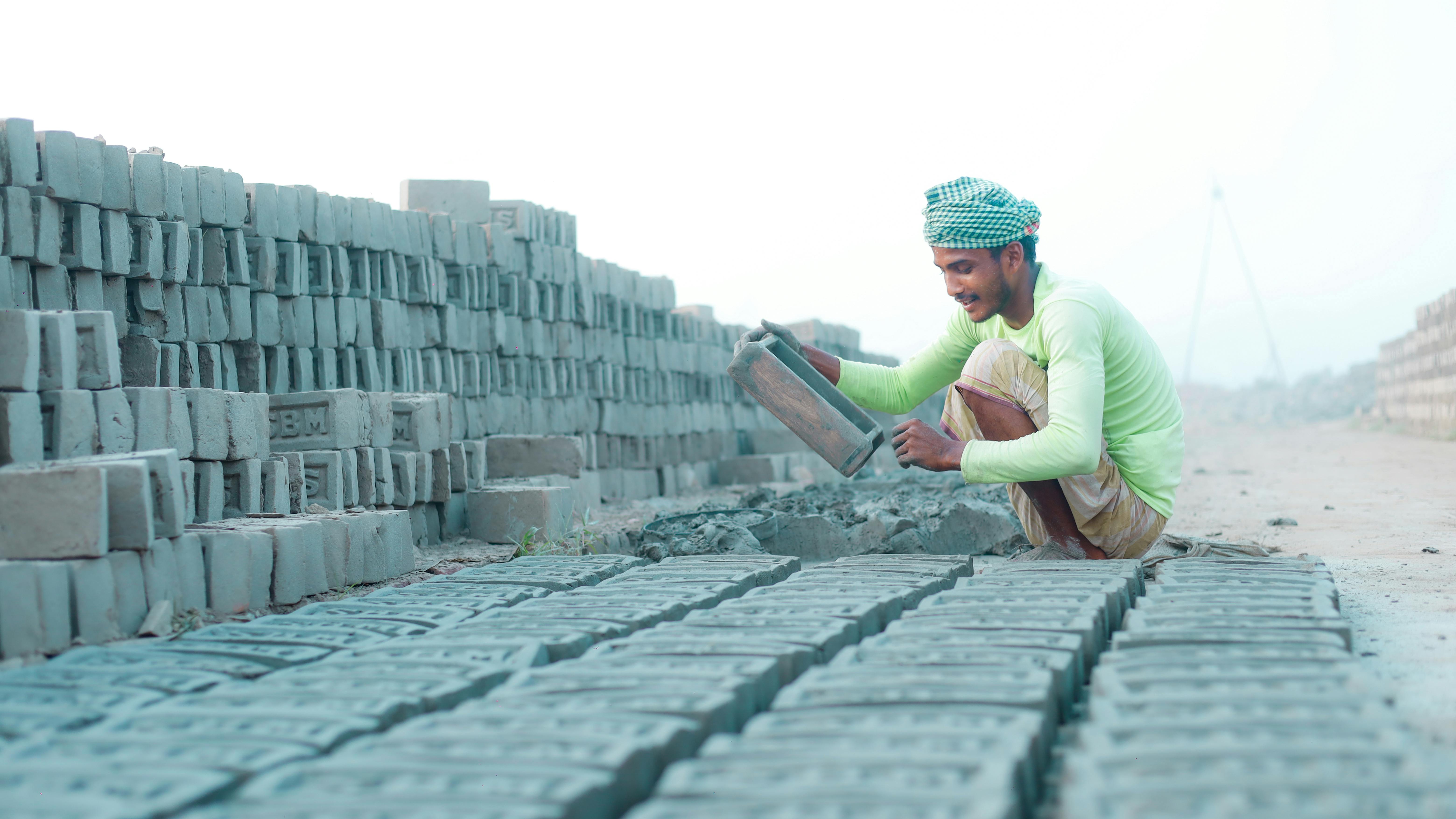 Man Laying Bricks on a Construction Site · Free Stock Photo