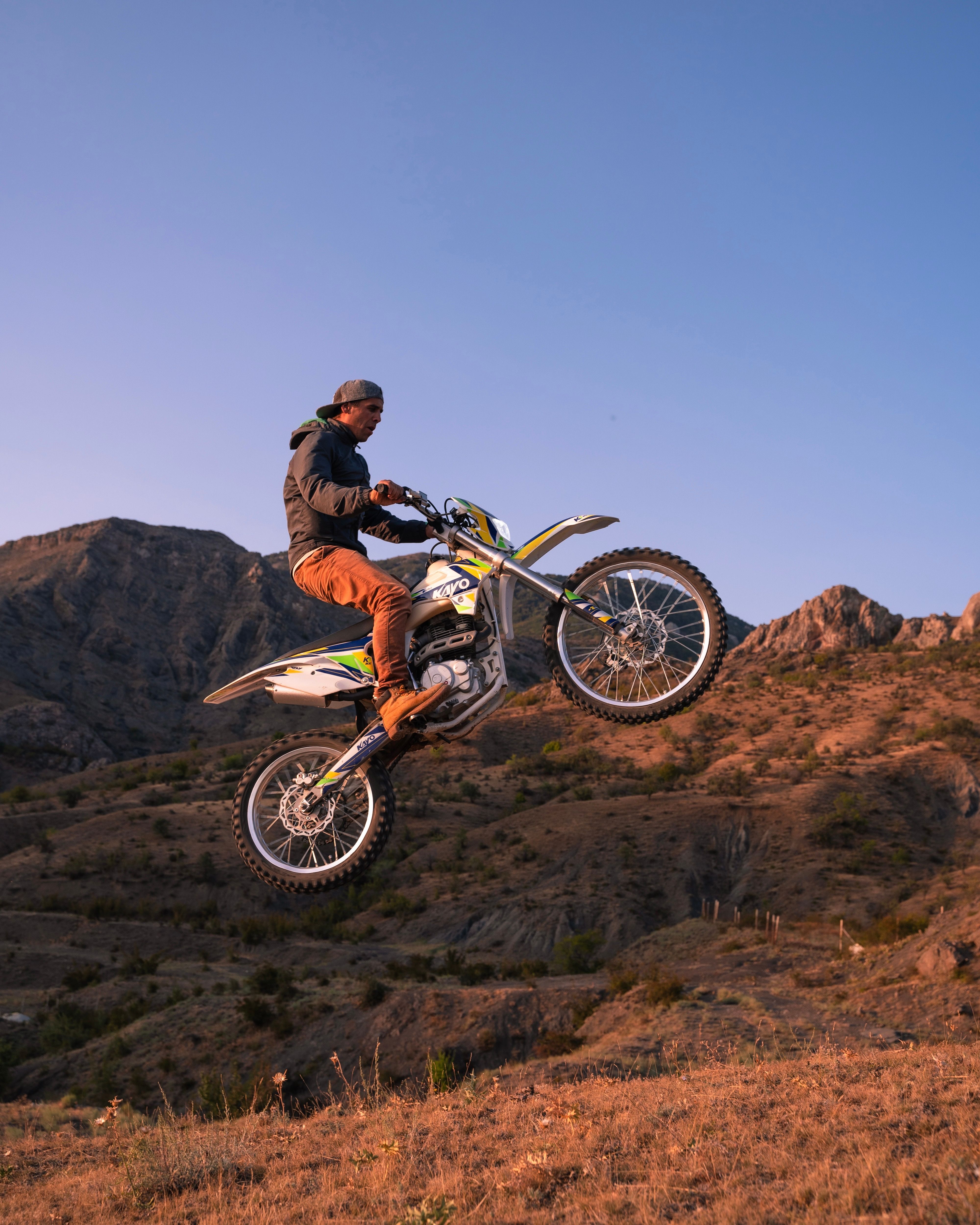 Man on Motorbike Jumping on Hill in Mountains Landscape · Free Stock Photo