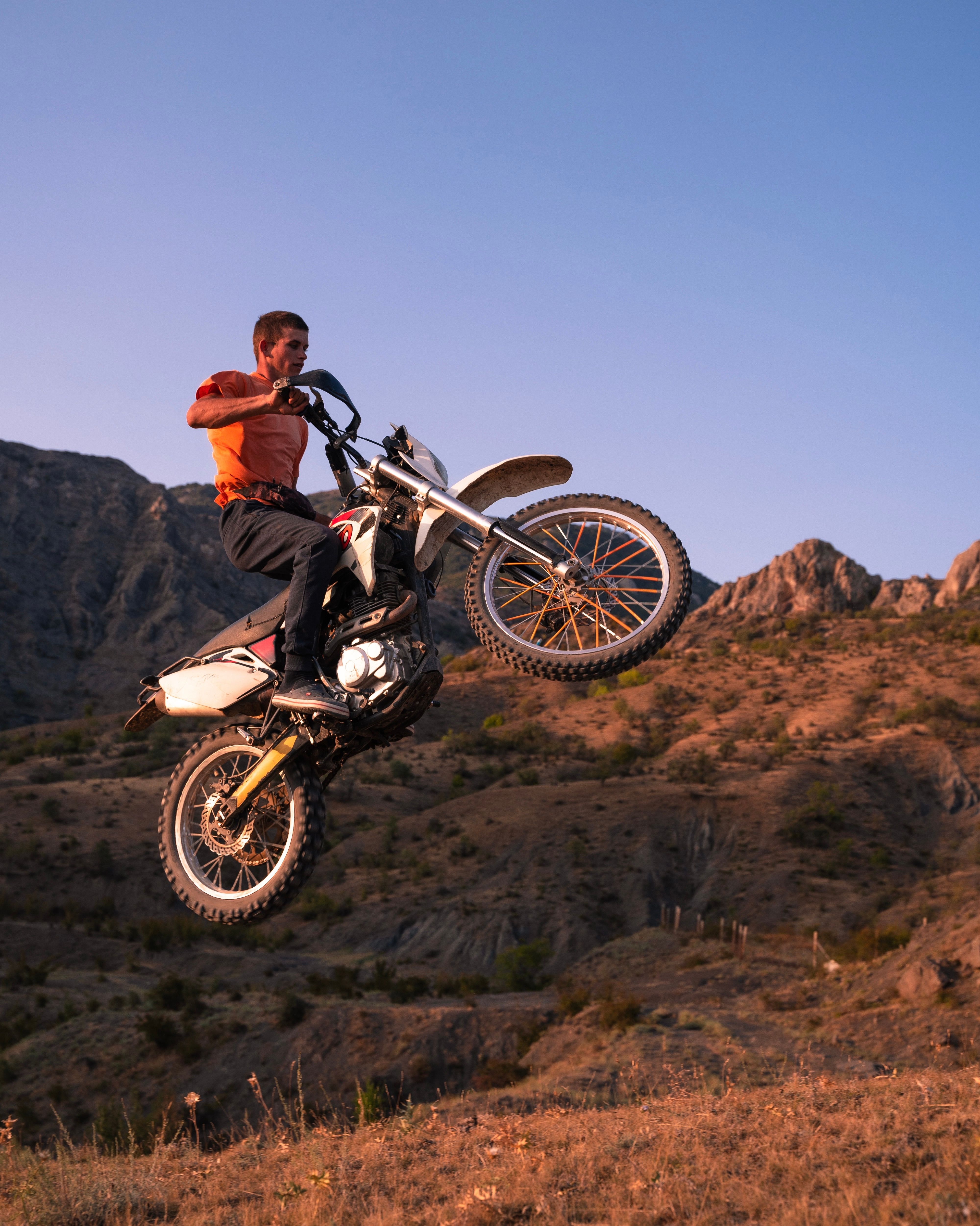 Man Jumping on Motorcycle in Mountains Landscape · Free Stock Photo