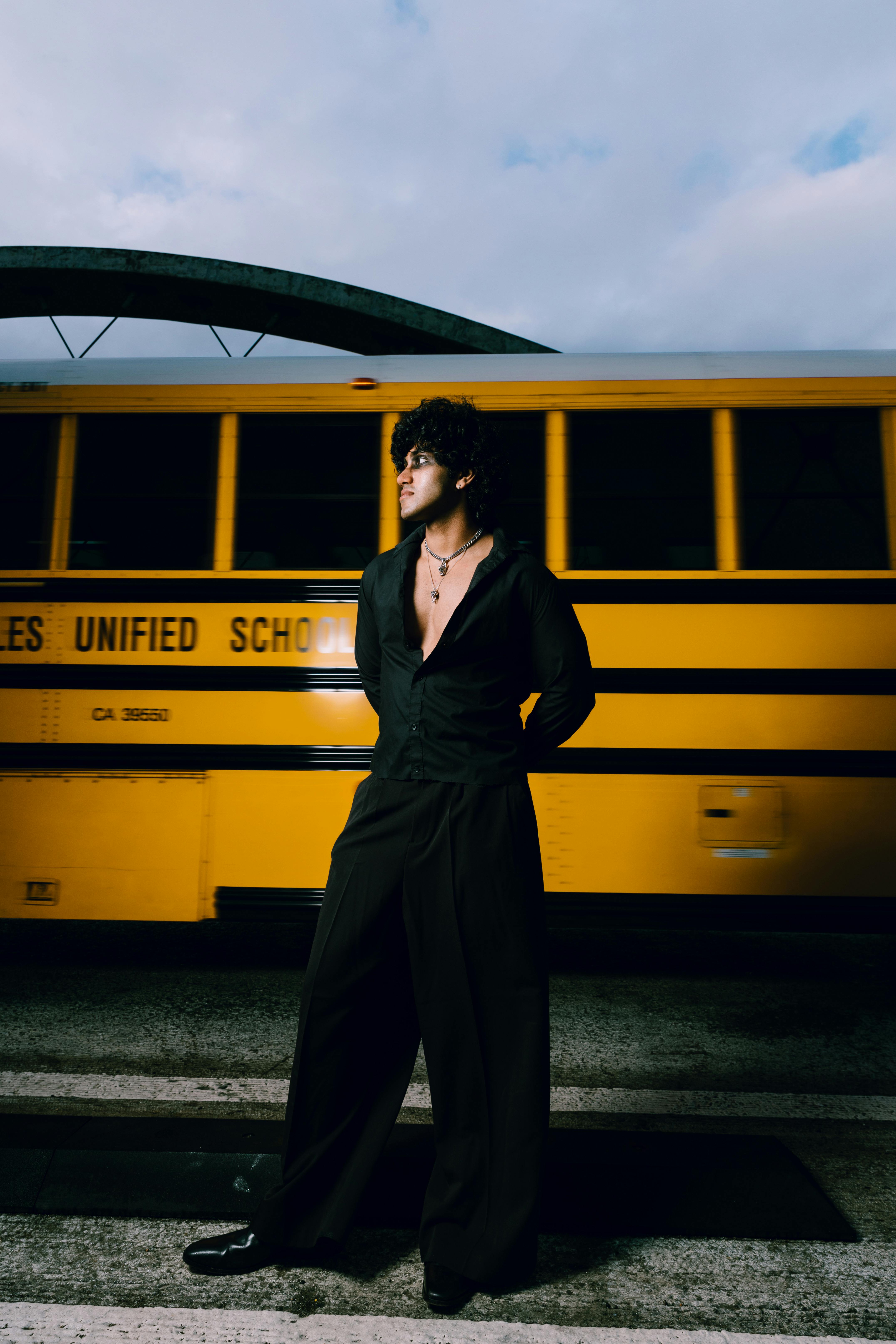 Man Posing by School Bus · Free Stock Photo