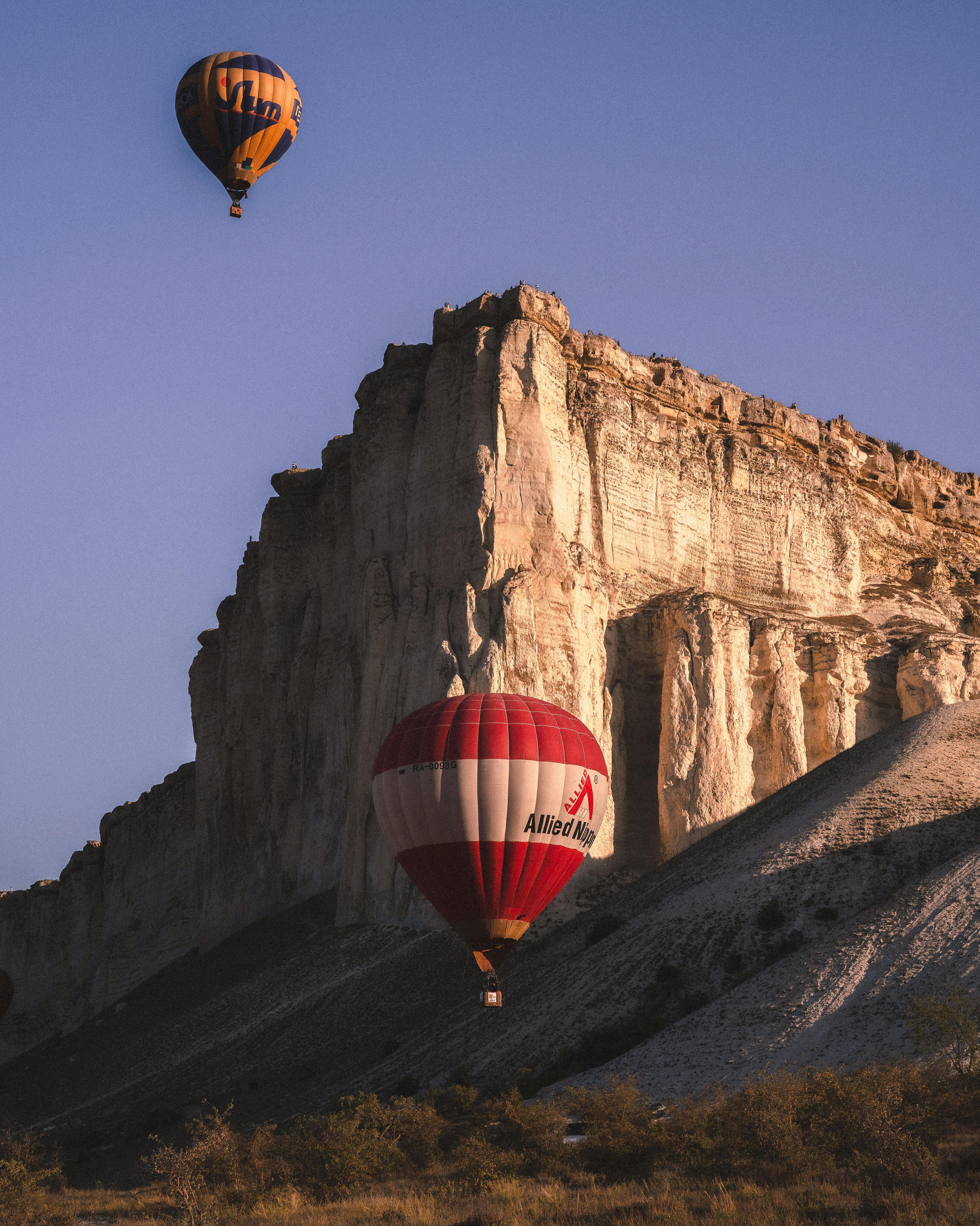 Balloons Flying near Rock Formation · Free Stock Photo