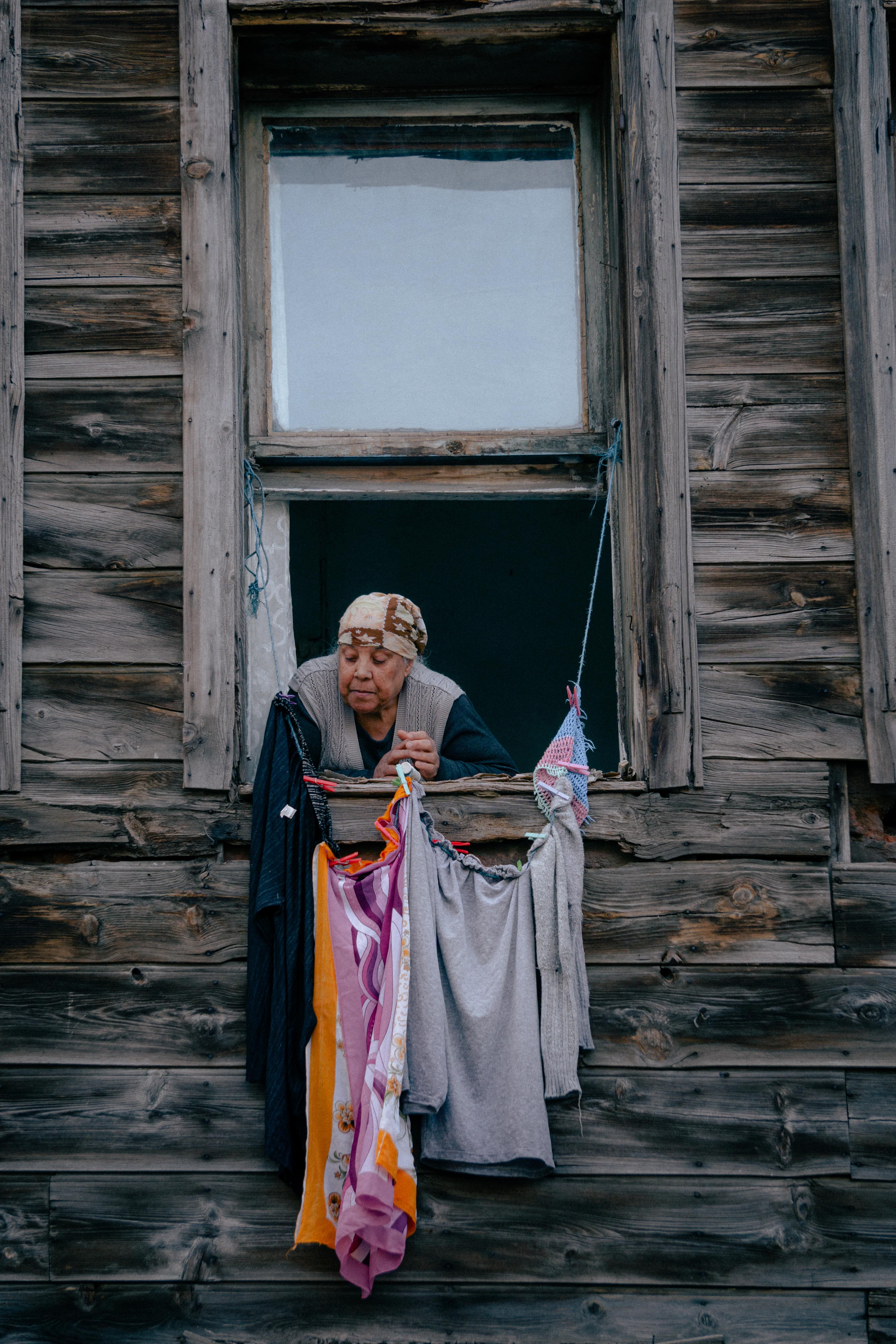 Woman in Window with Drying Clothes below · Free Stock Photo