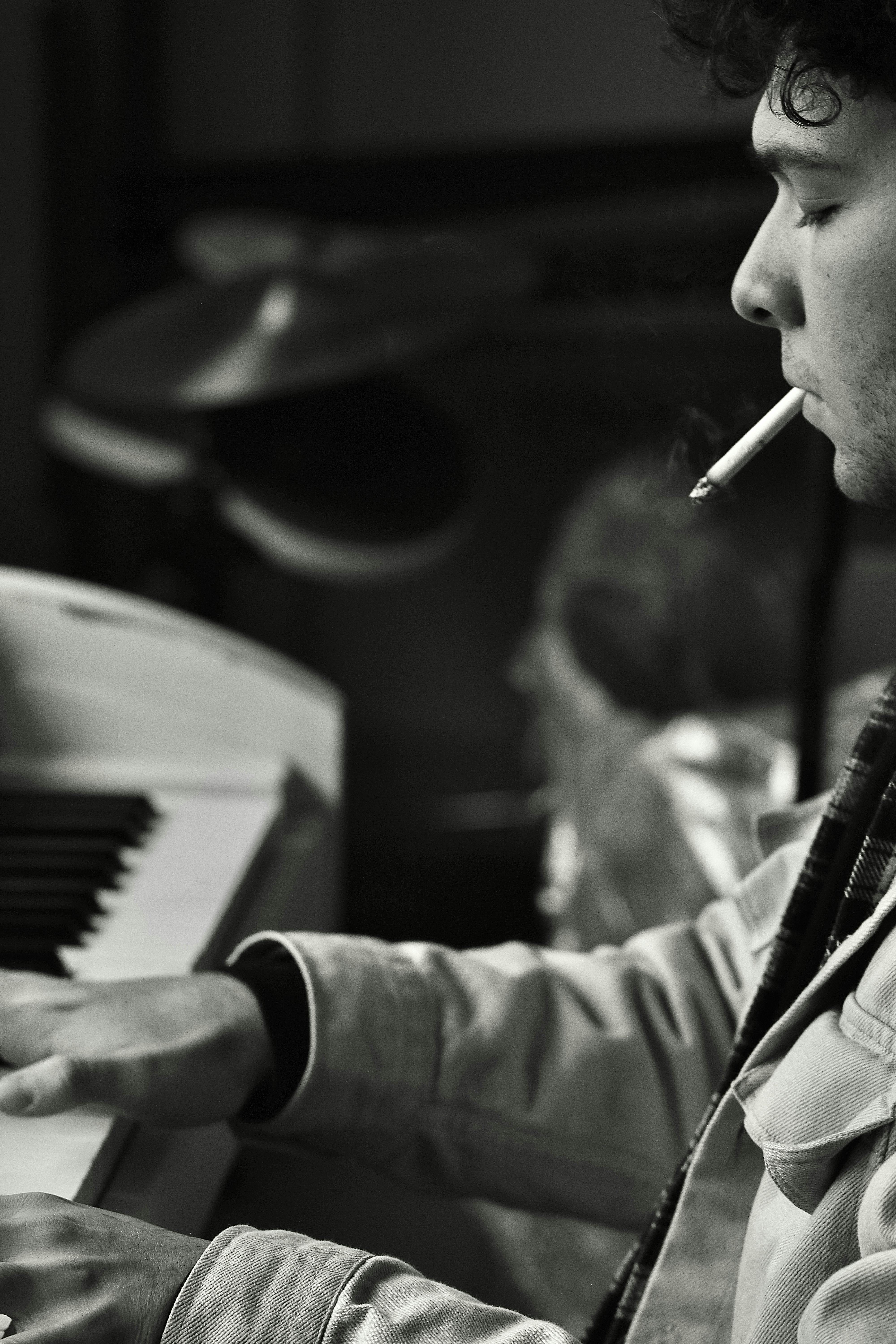 Man Smoking and Playing Keyboard in Black and White · Free Stock Photo