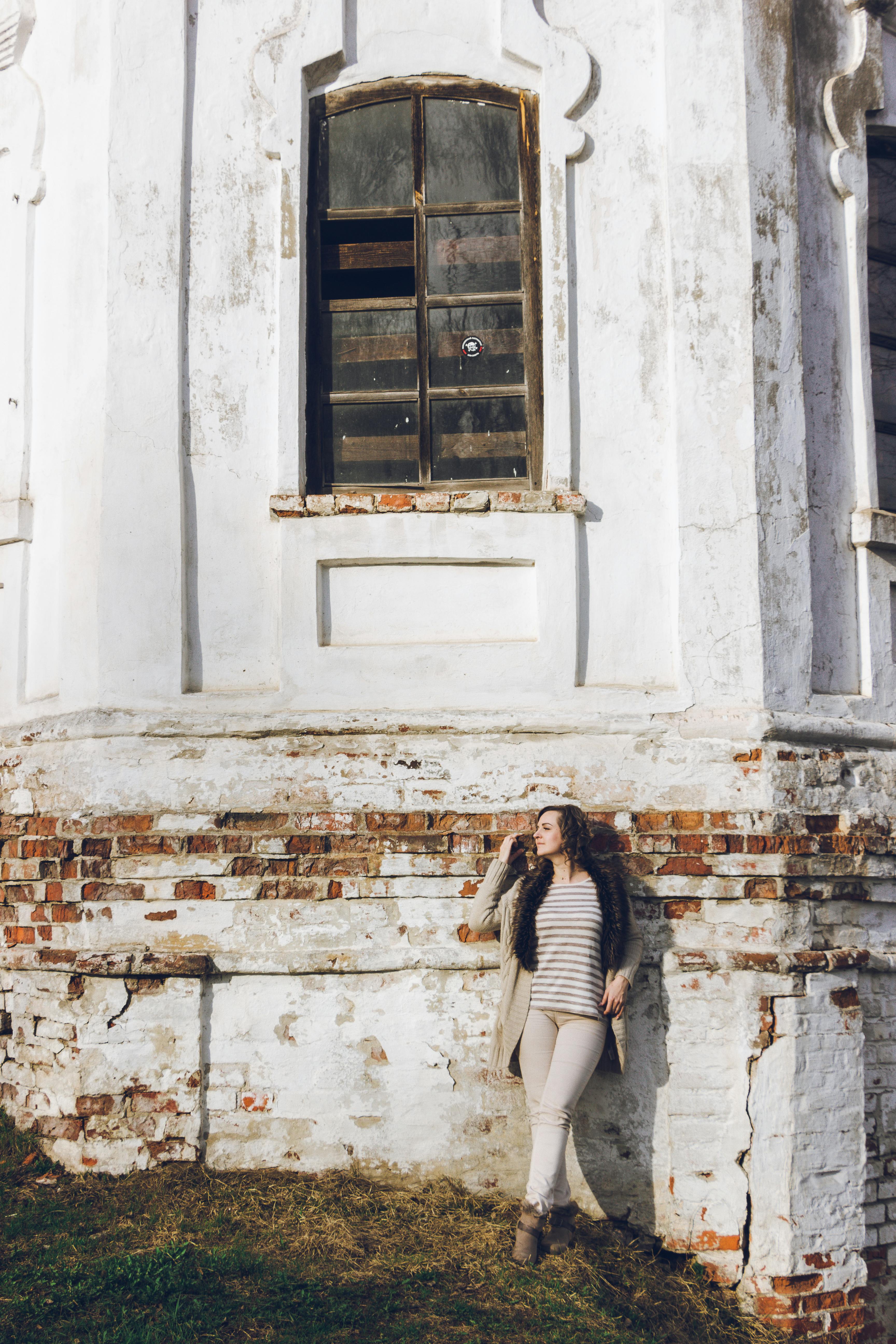 Woman Posing near Old Brick Building Wall · Free Stock Photo