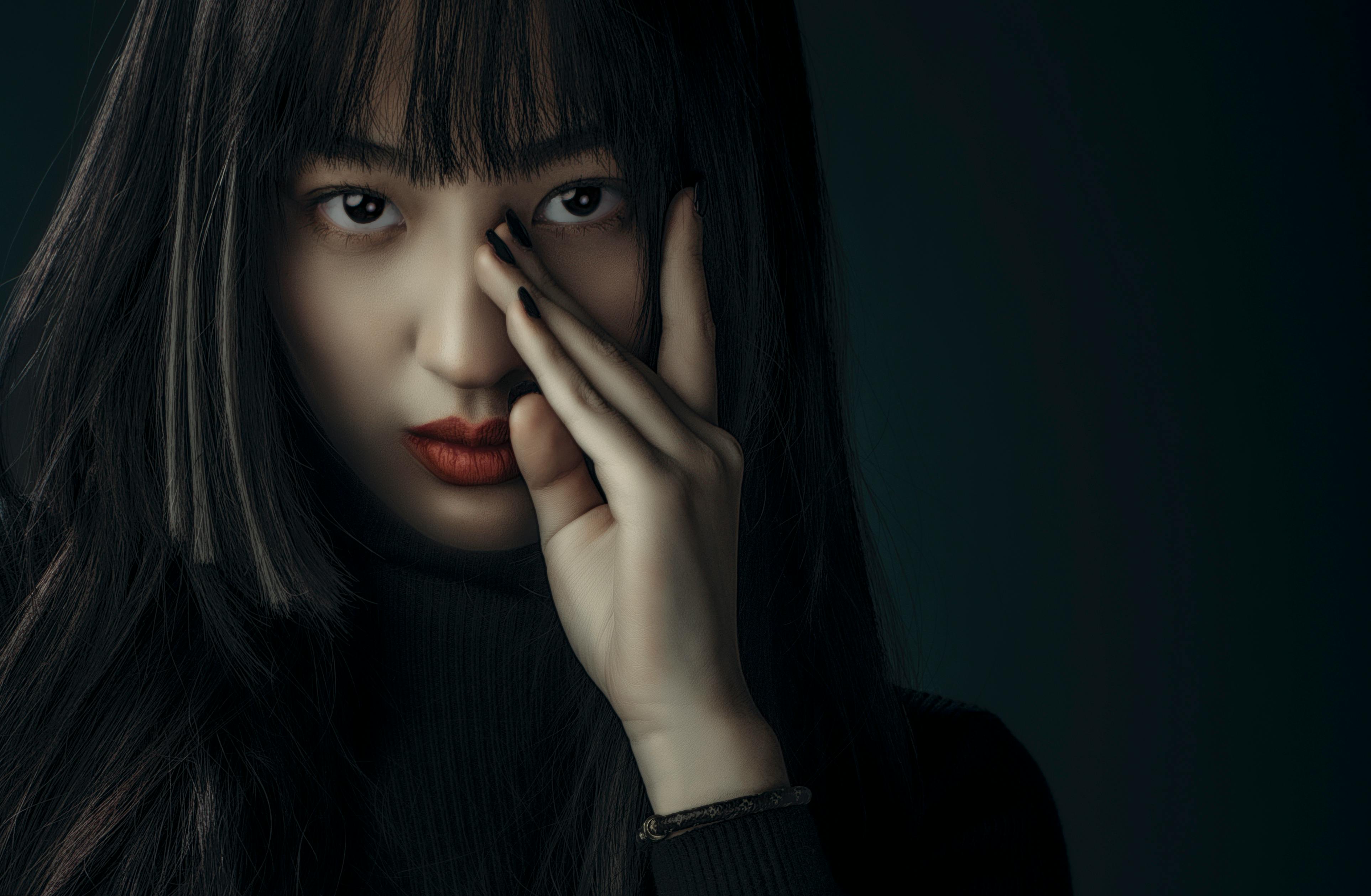 Woman with a Fringe Gesturing by her Eye · Free Stock Photo