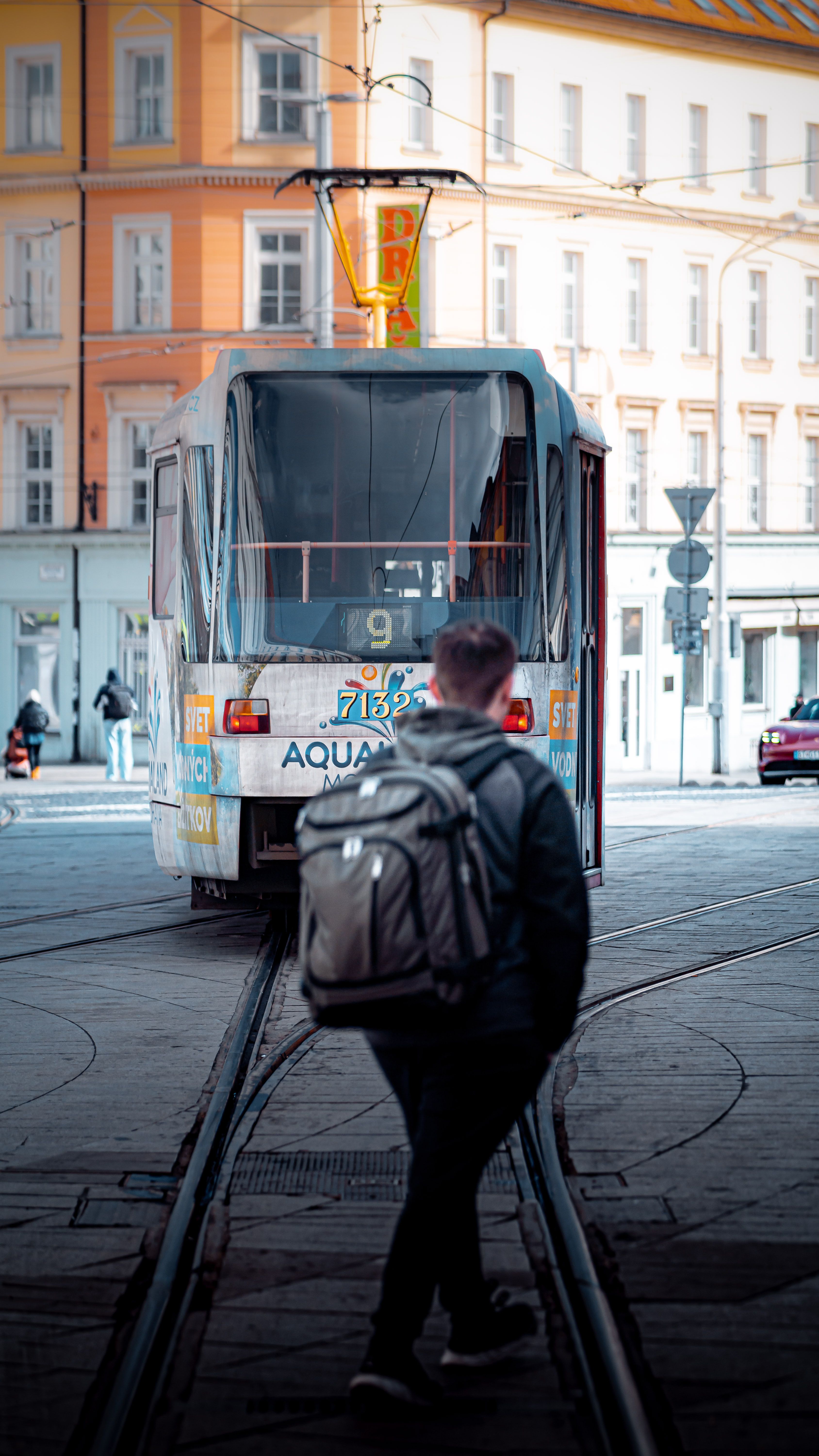 People Walking on Tram Rails on a Narrow City Street · Free Stock Photo