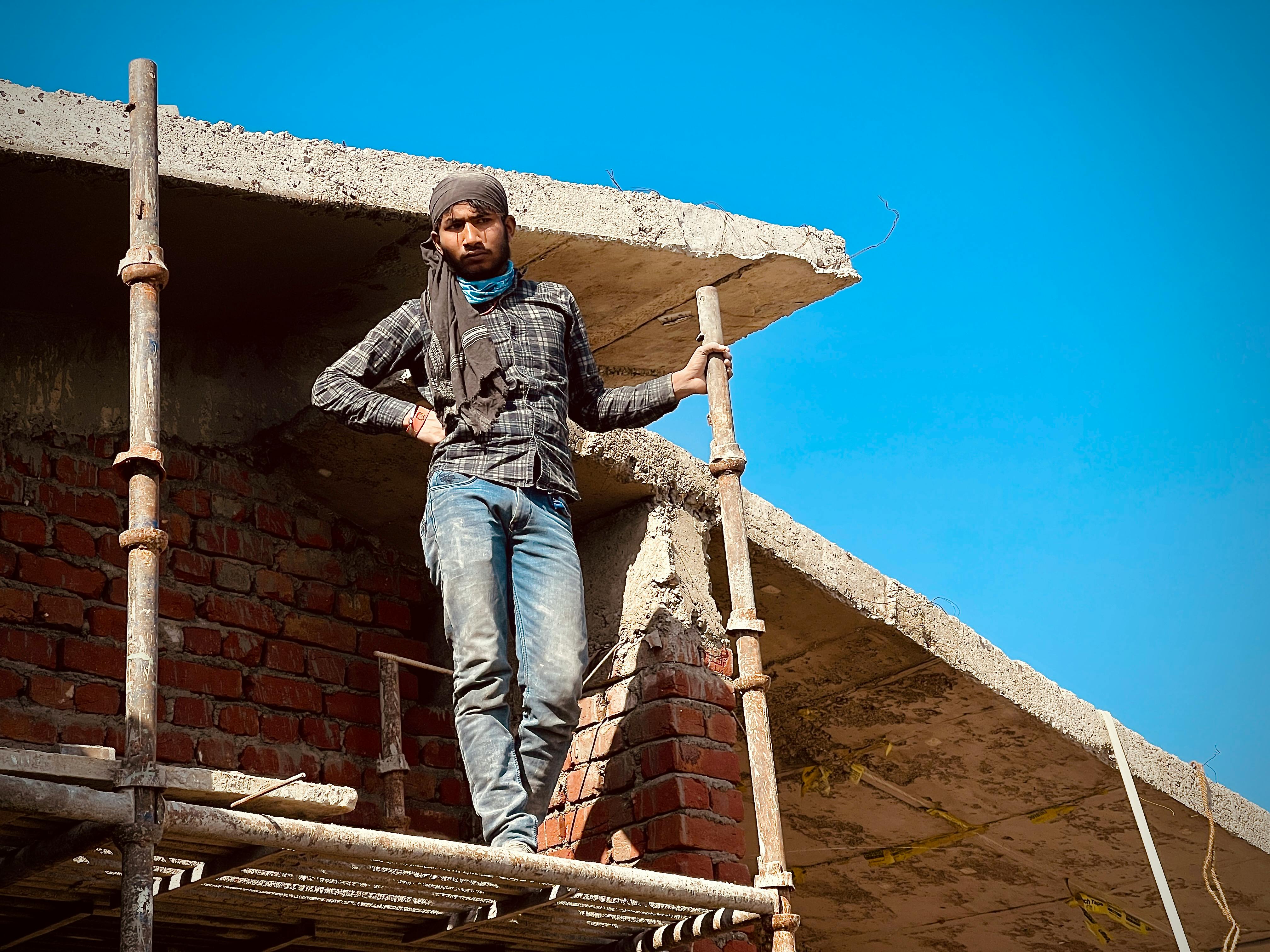 Man Standing on Scaffolding by Commercial Sign · Free Stock Photo