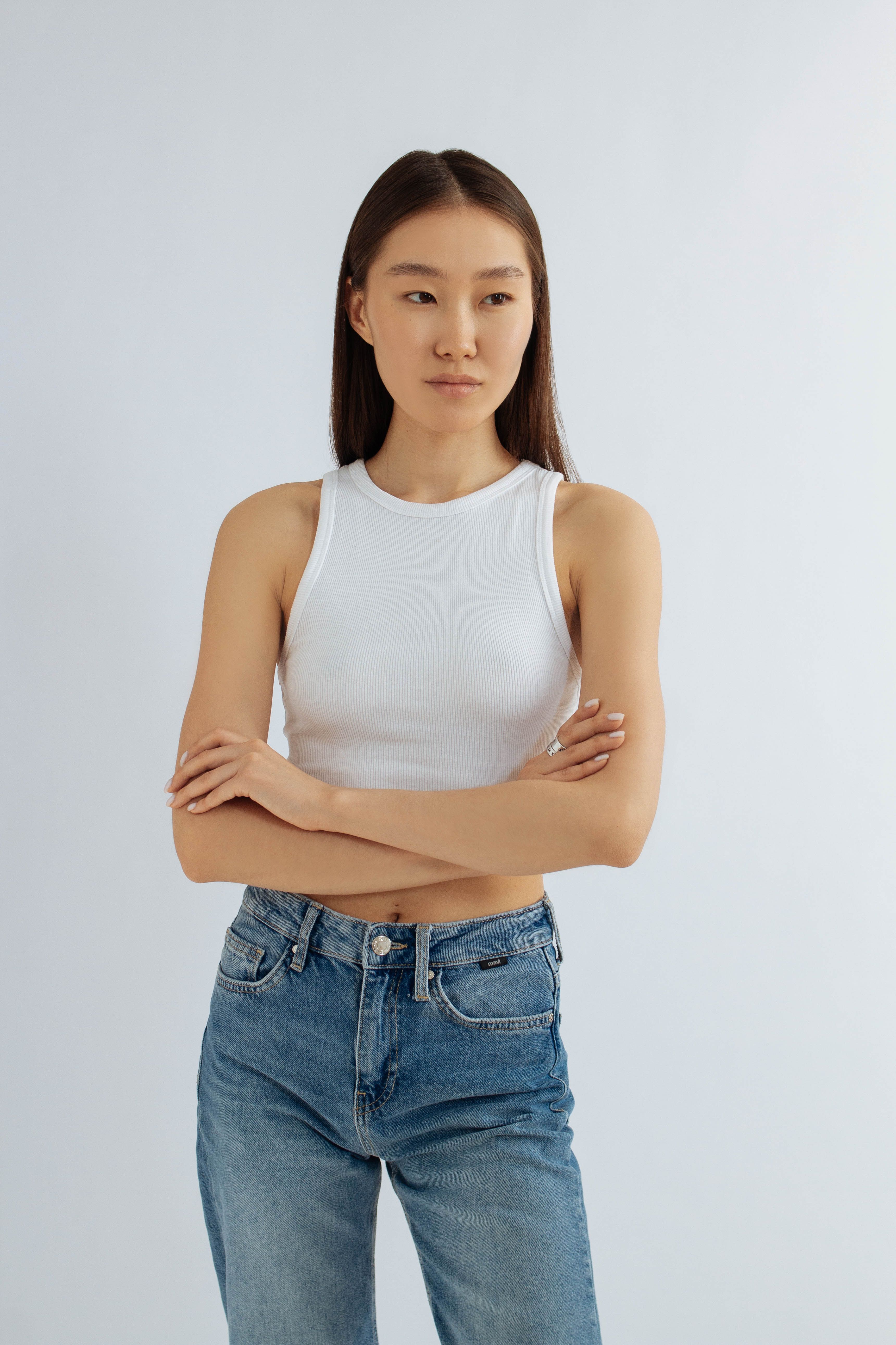 Woman Standing with Arms Crossed on White Back · Free Stock Photo