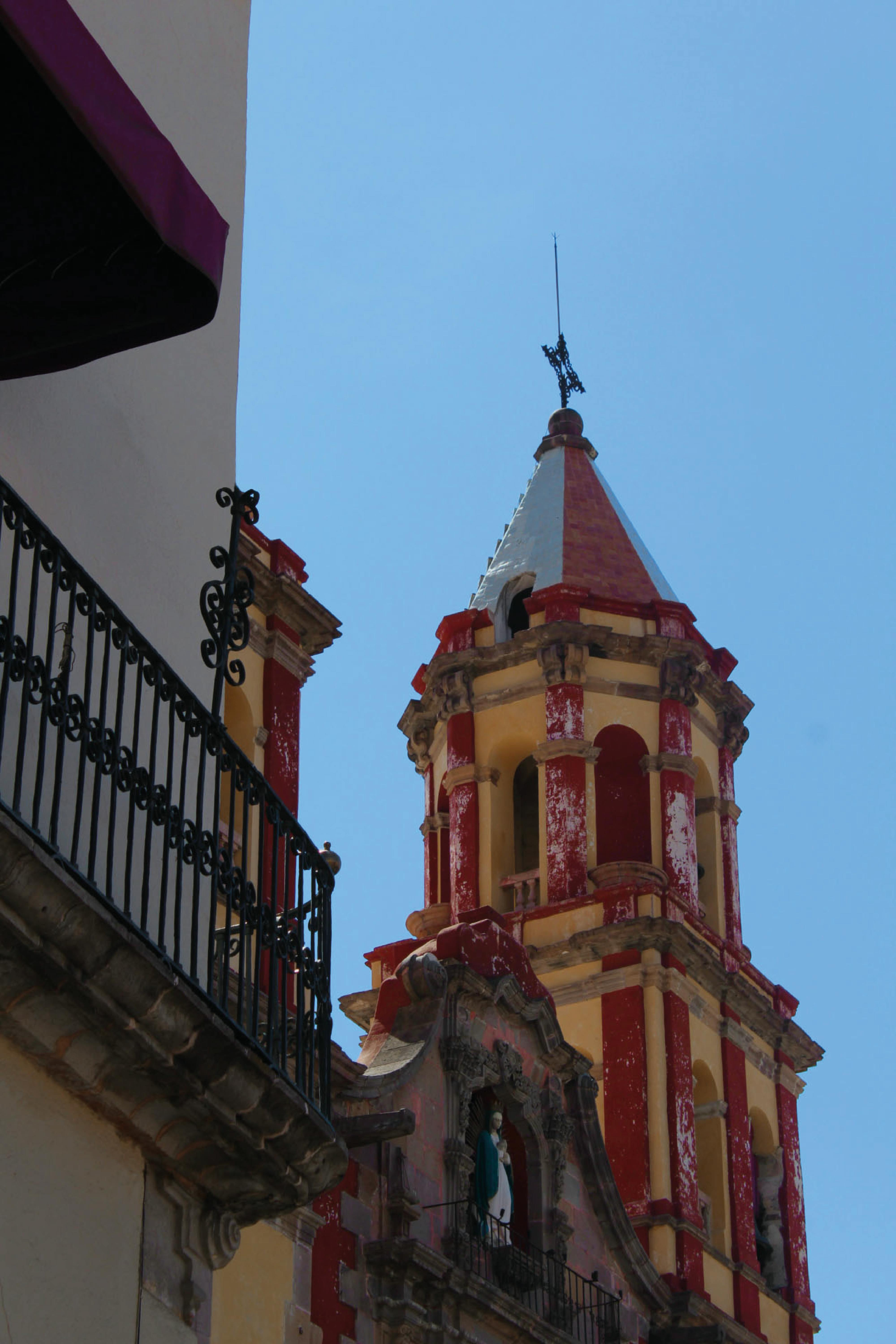 A church tower with a red and white spire · Free Stock Photo