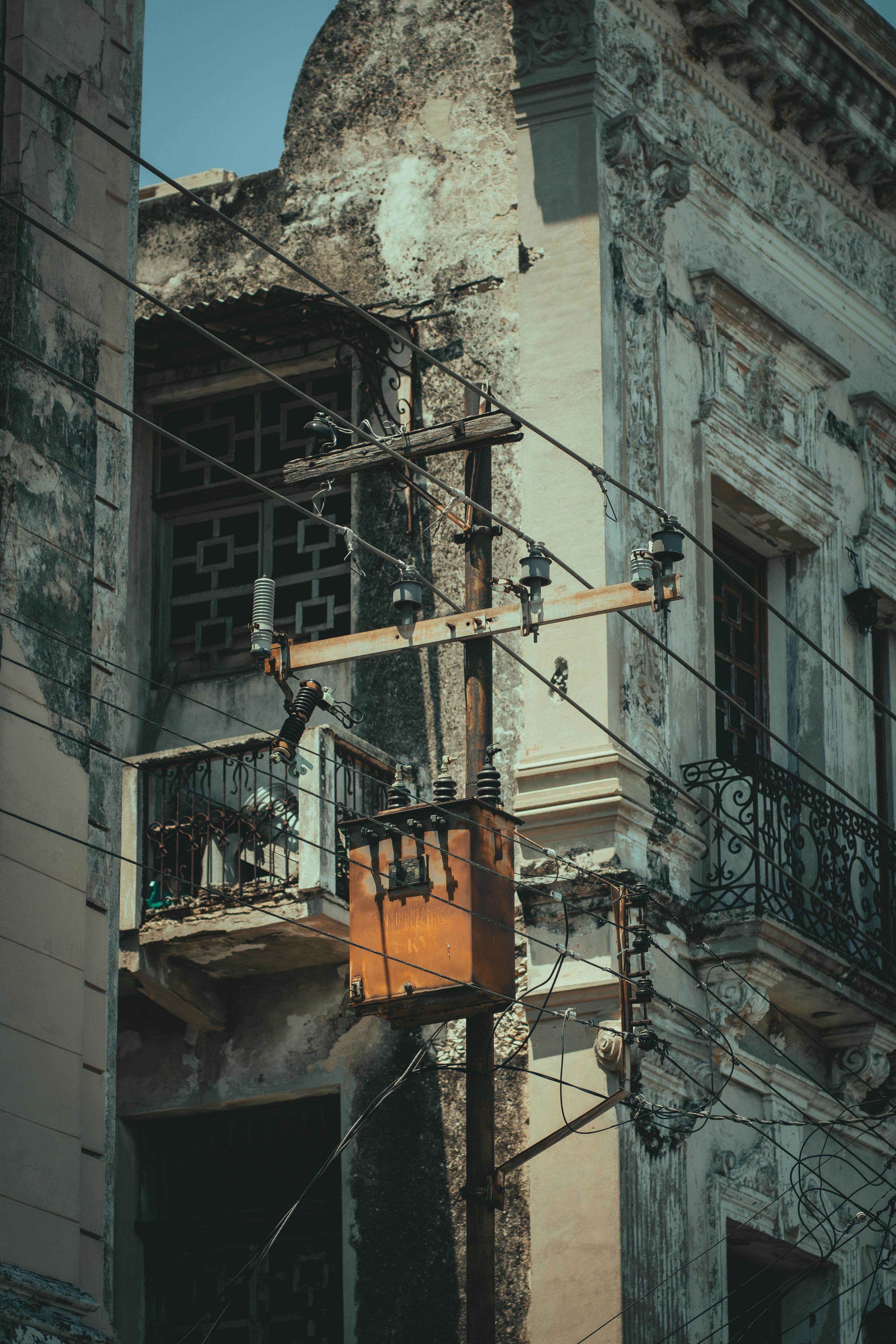 Power Lines and Damaged Building Wall behind · Free Stock Photo