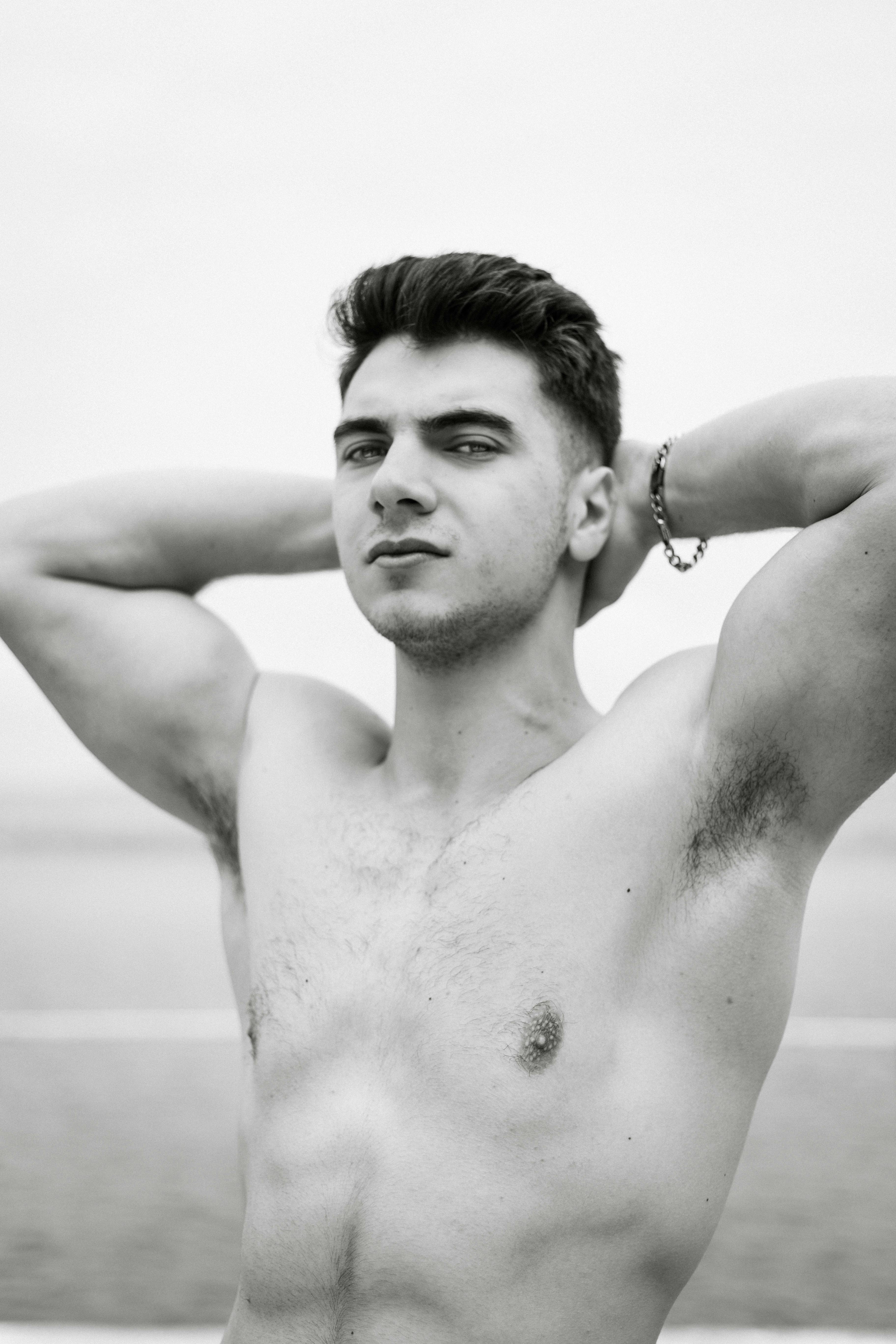 Man with Muscles Posing Topless behind Fence · Free Stock Photo