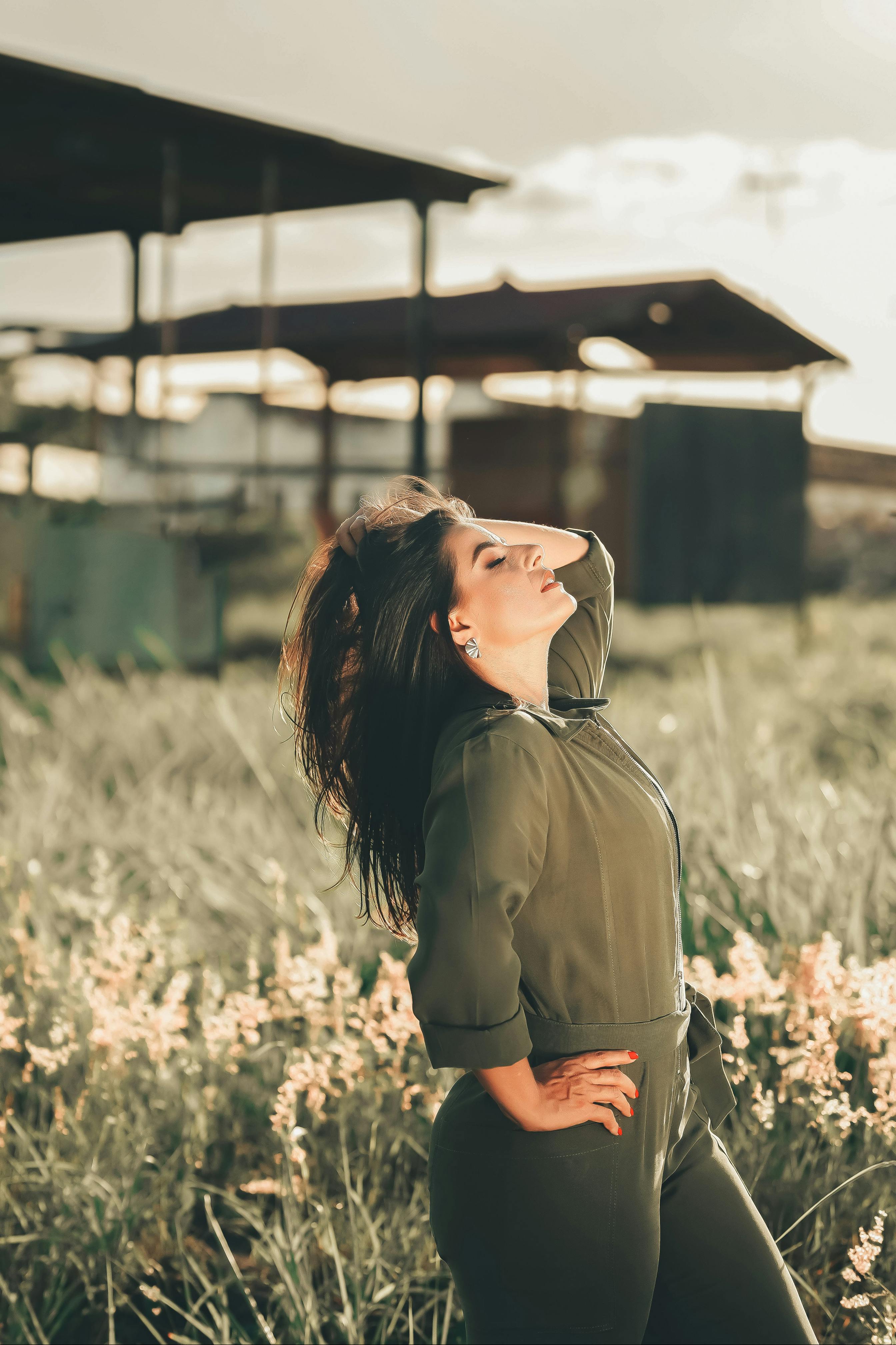 Woman Ruffling her Hair in a Field · Free Stock Photo