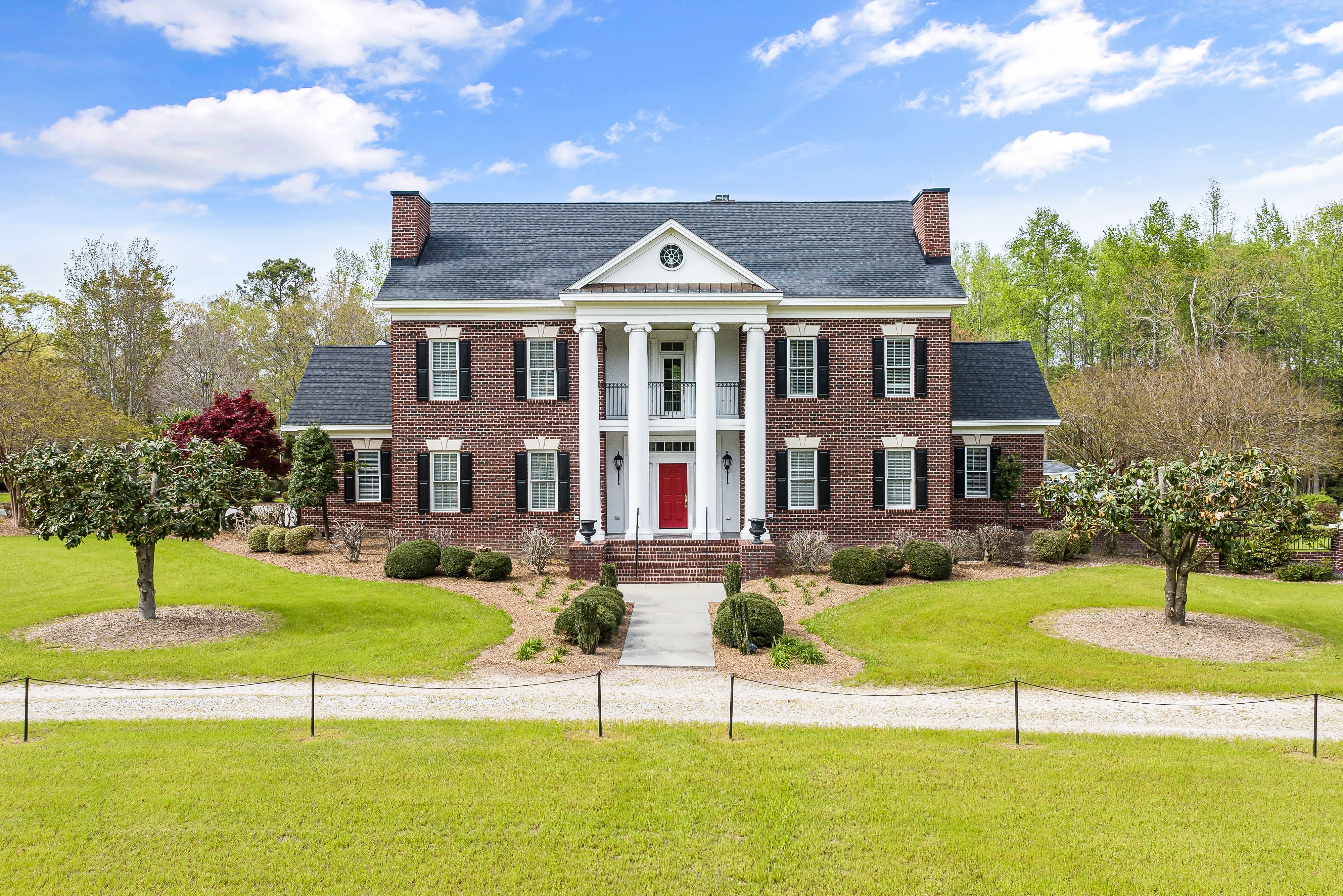 Symmetrical Image of a Residential Building with Columns and a Garden ...