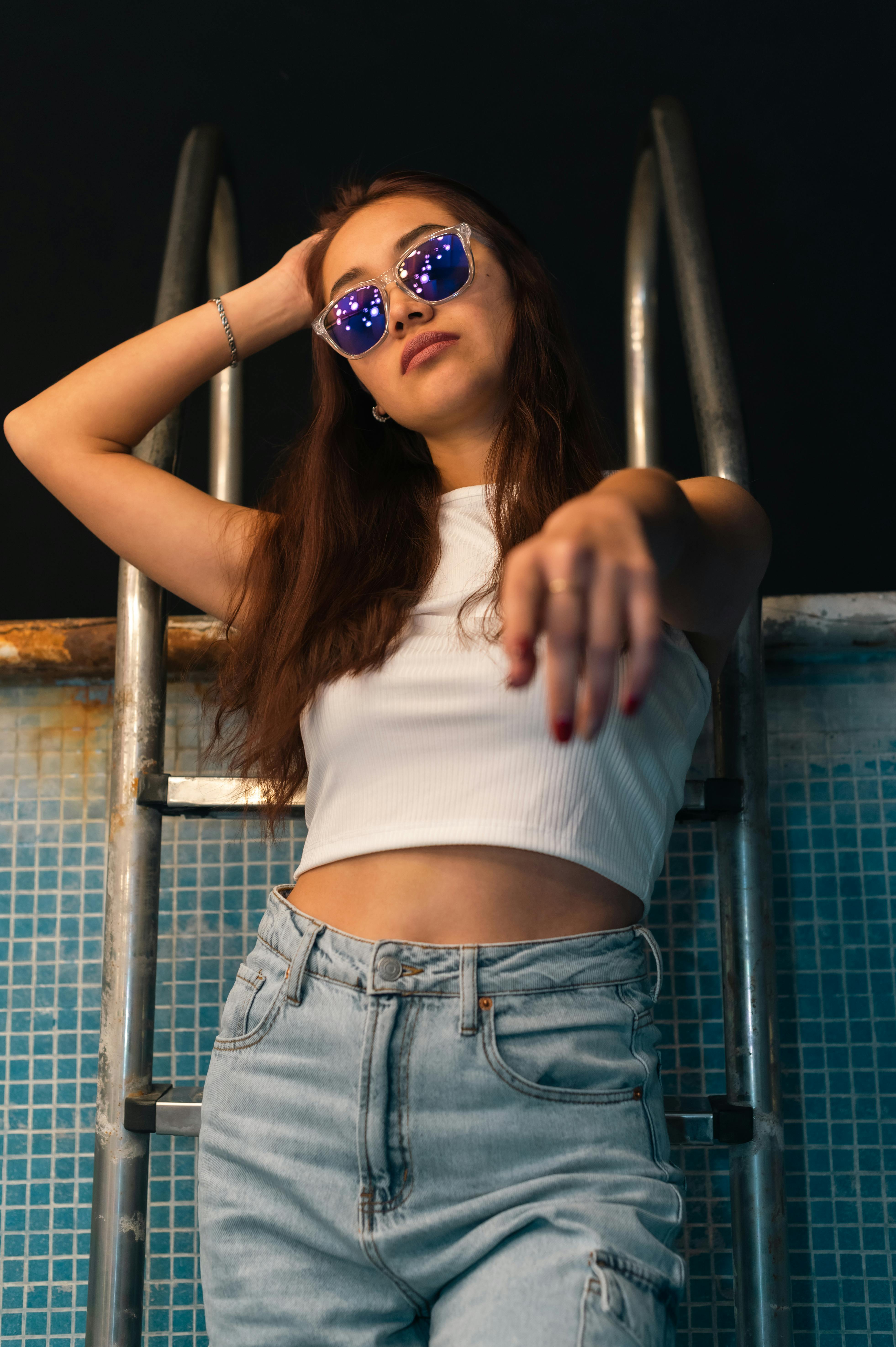 Model in a White Crop Top Without Sleeves and Jeans Posing in an ...