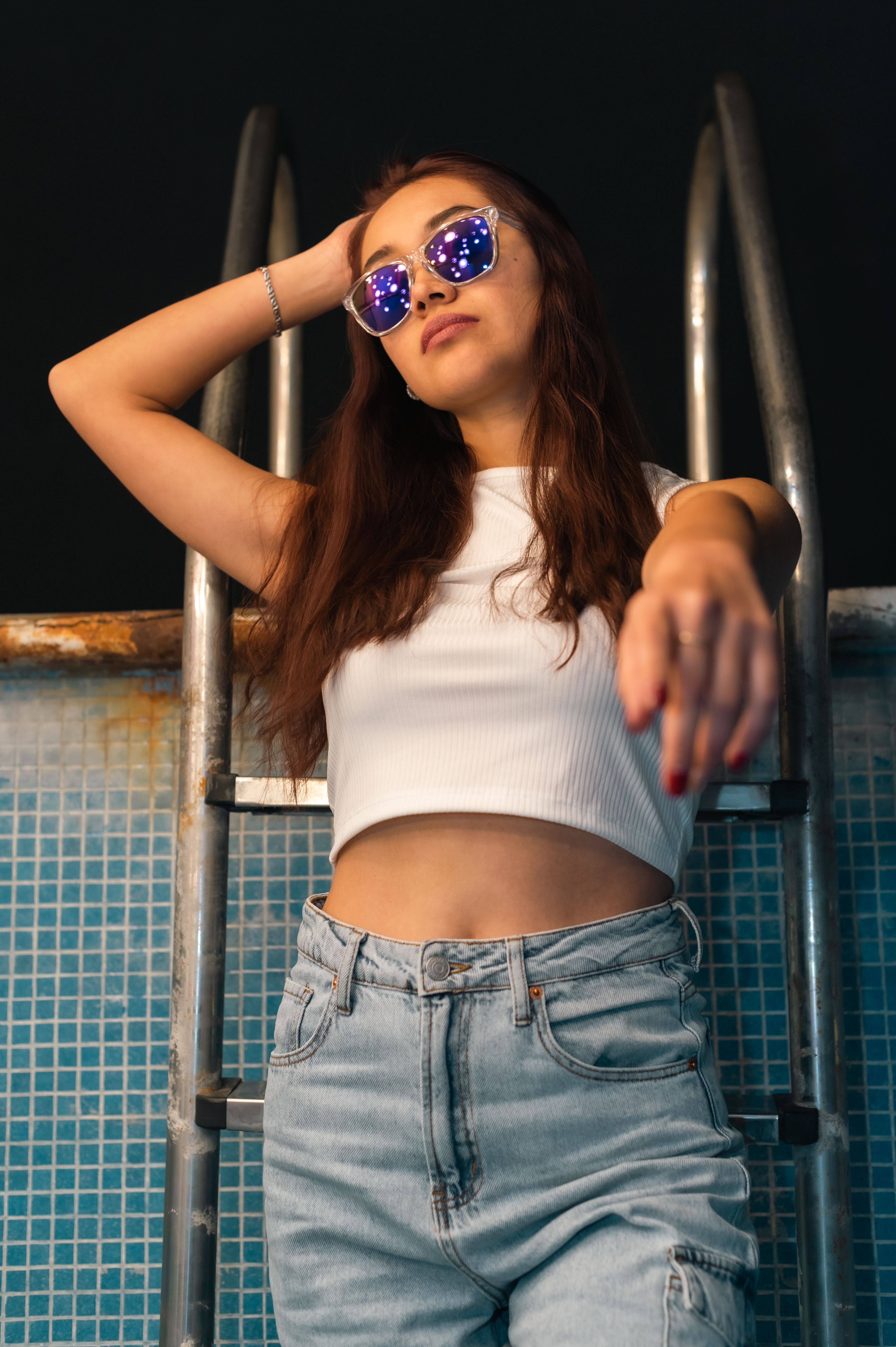 Model in a White Crop Top and Jeans Posing in an Old Swimming Pool ...