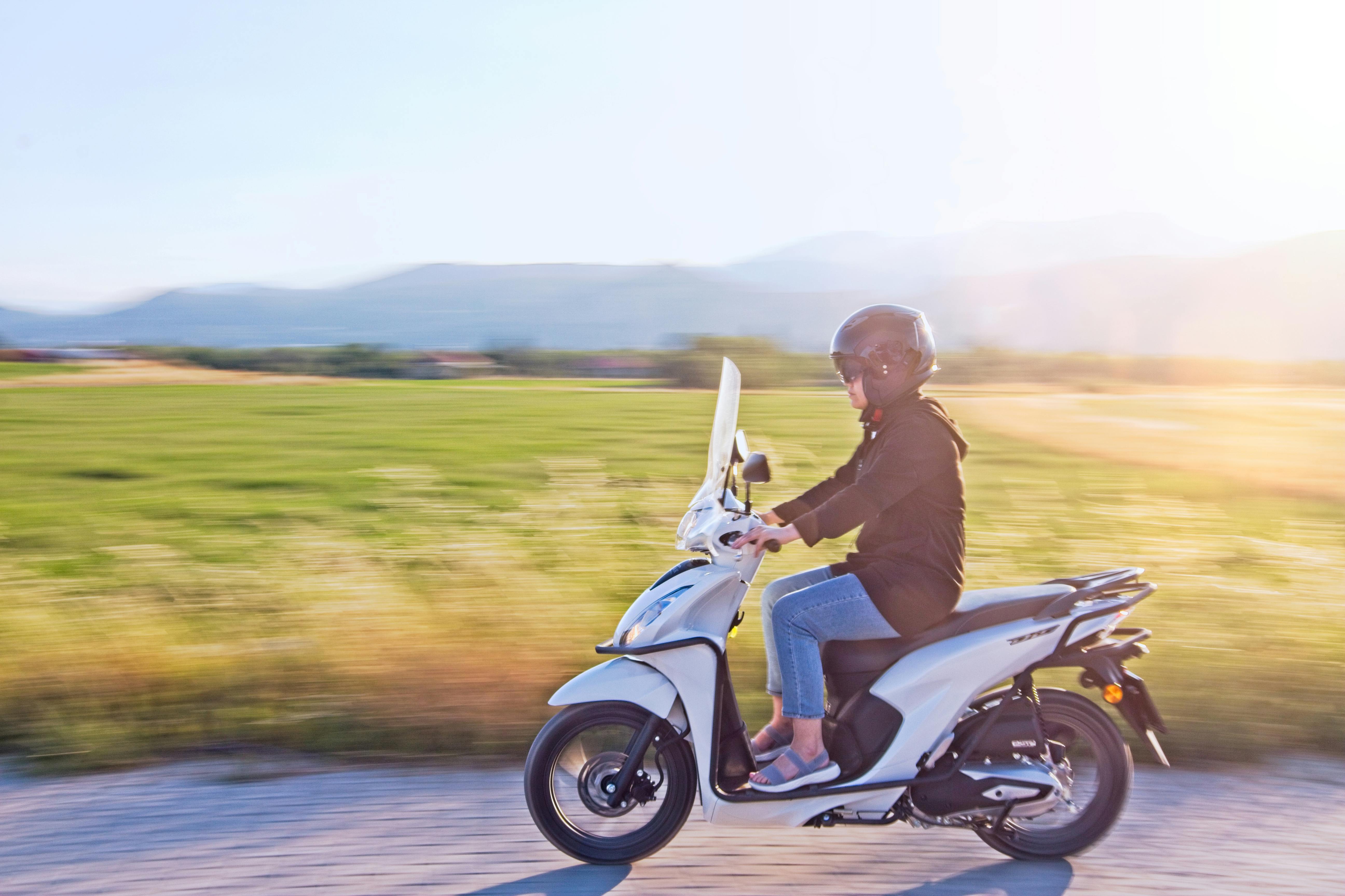 Woman Riding Motor Scooter Travelling on Asphalt Road during Sunrise ...