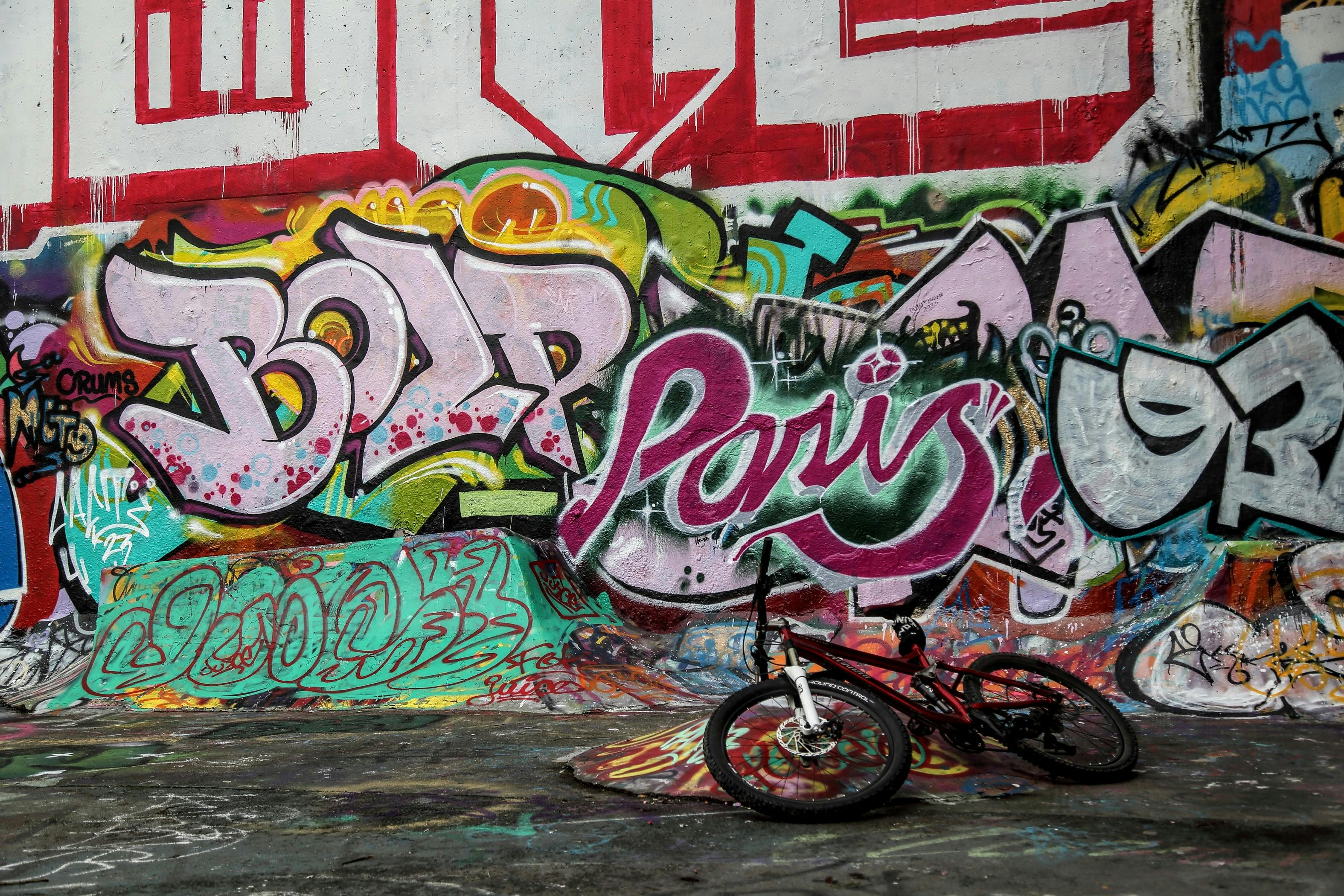 A Bicycle Lying on the Ground in front of a Wall with Graffiti · Free ...
