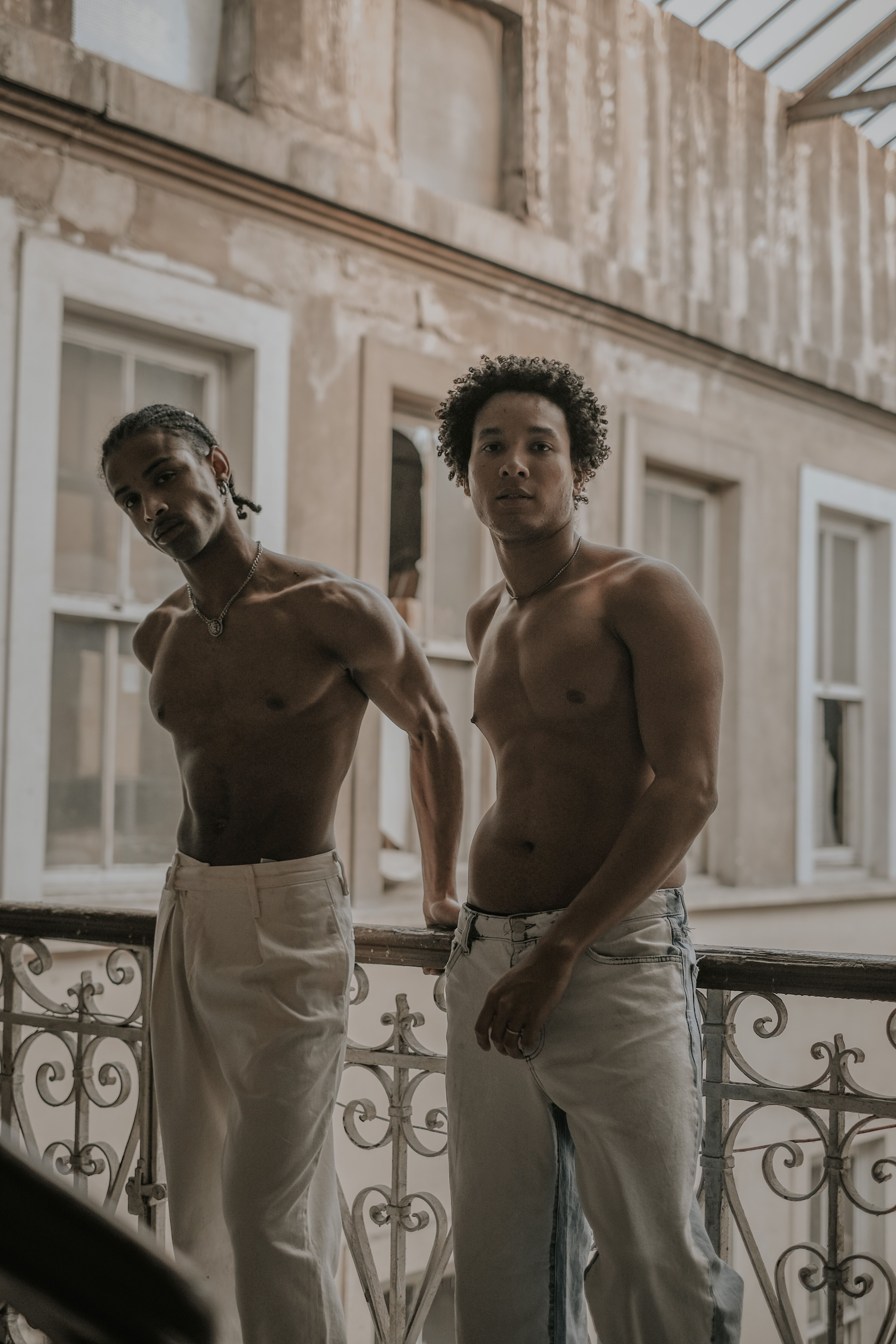 Two Young Men Standing Back to Back in front of an Apartment Building ...