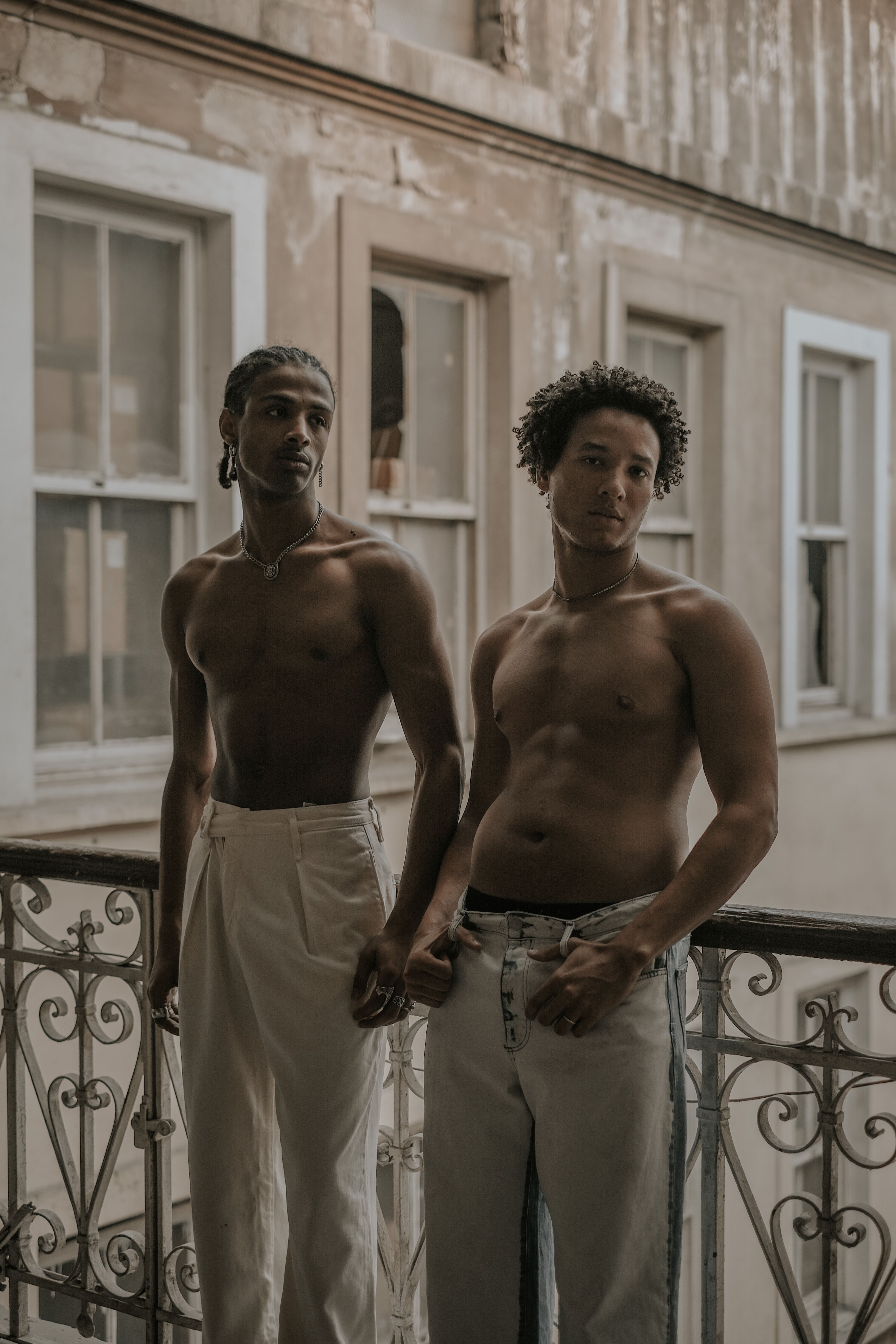 Two Young Men Standing Back to Back in front of an Apartment Building ...