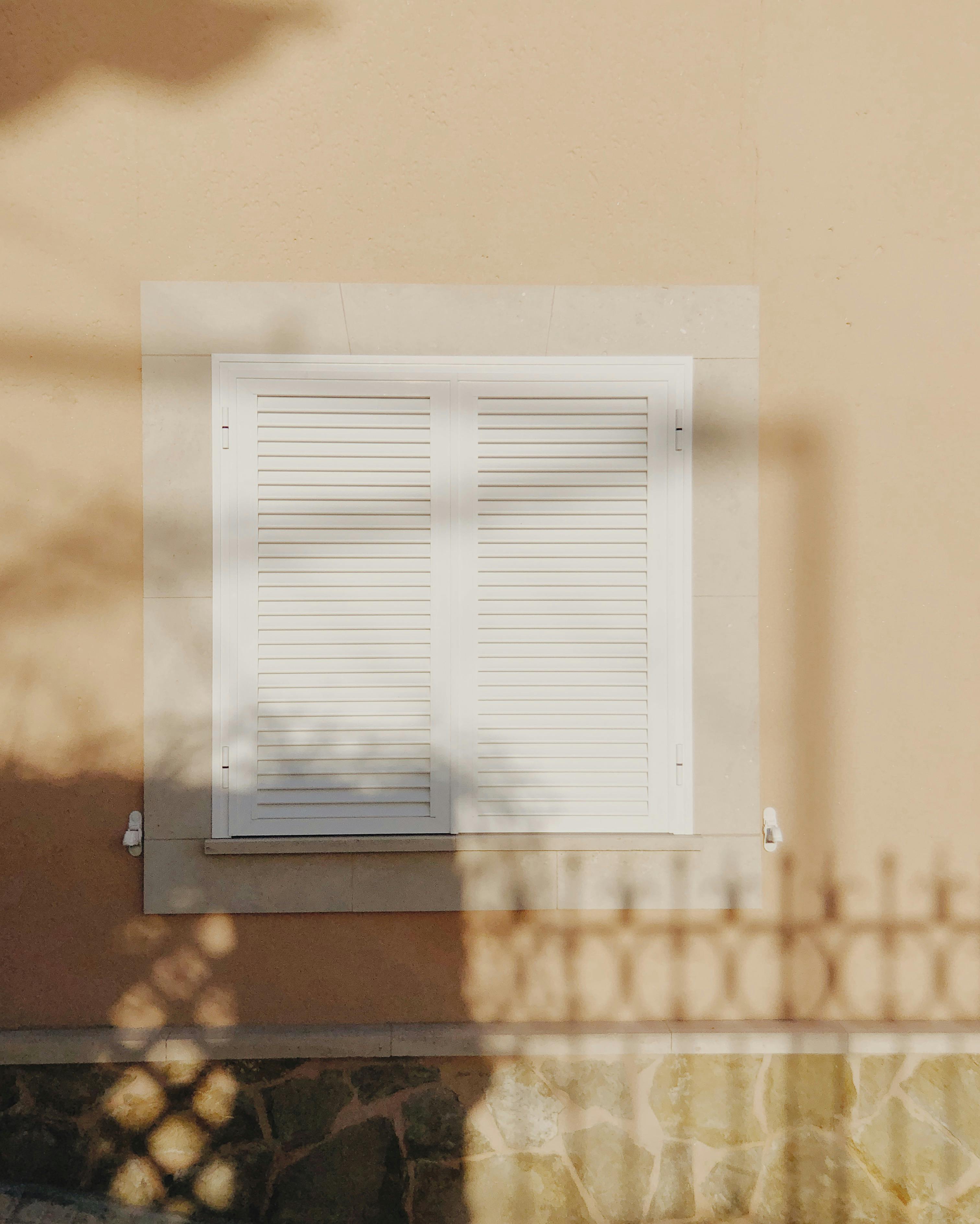 Building Exterior and a Window with White Shutters · Free Stock Photo