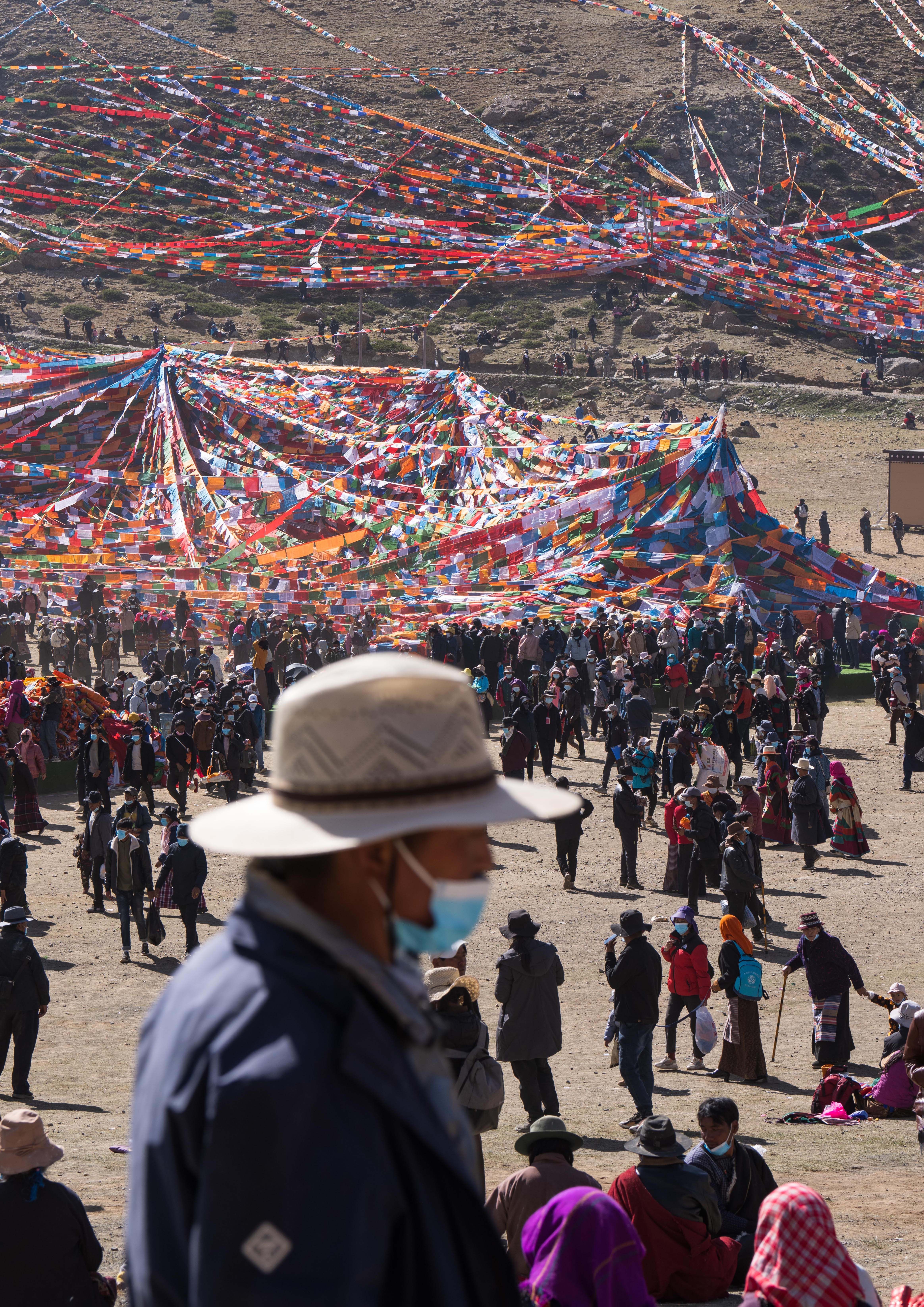 A Man in a Face Mask Against the Festival Crowd · Free Stock Photo