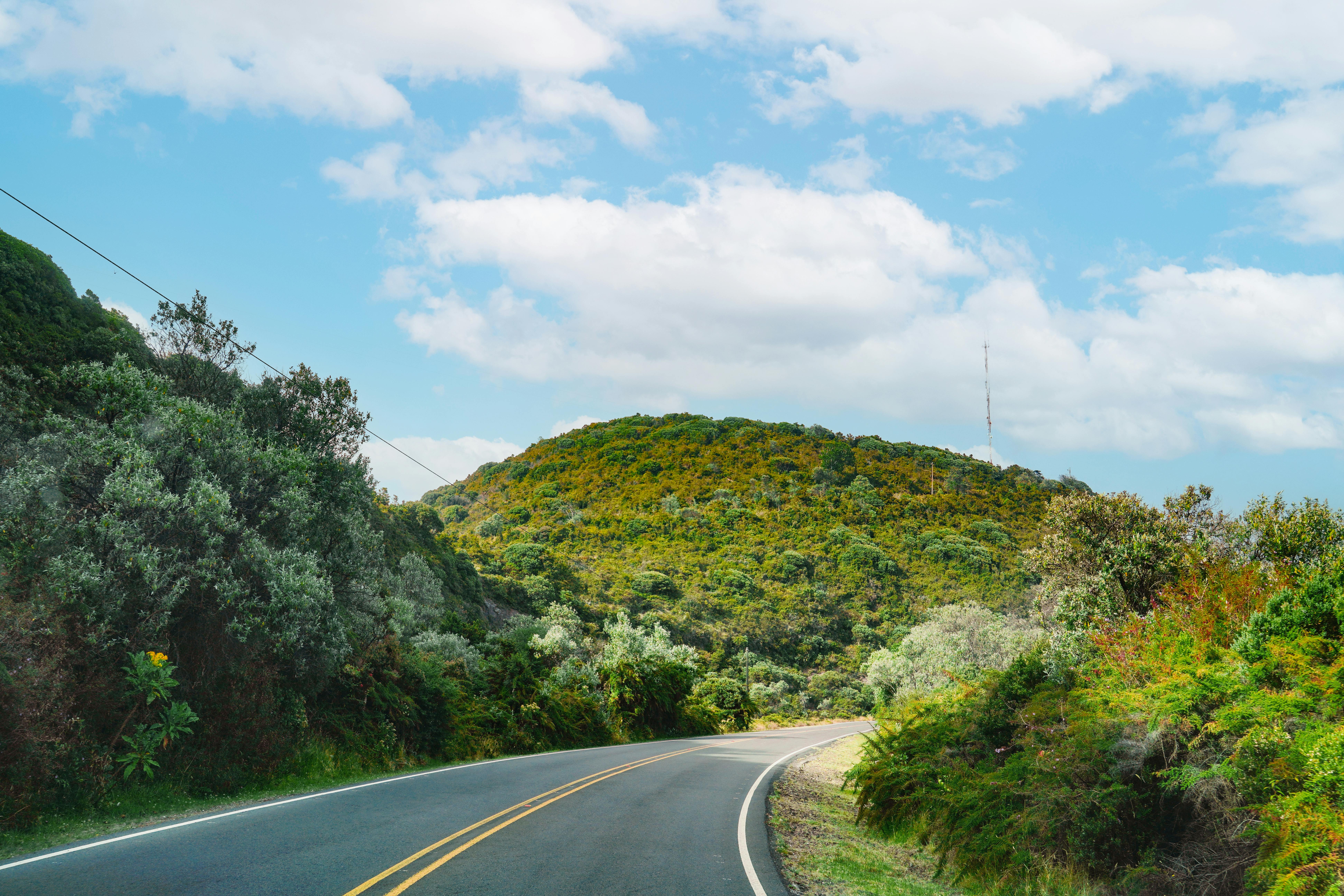 Photo of a Road with a View of a Green Hill · Free Stock Photo