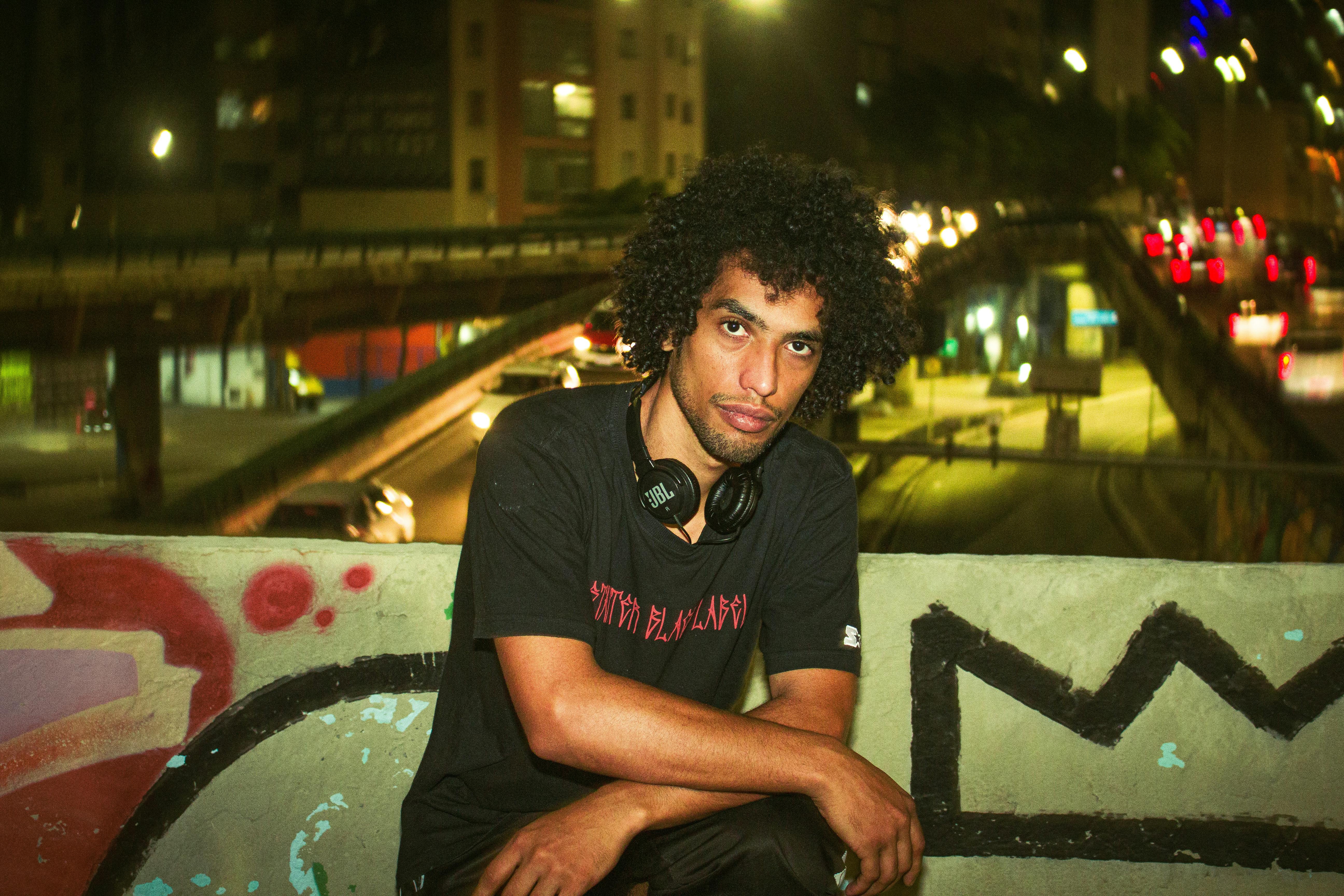 Photo of a Young Man Crouching Above the Street · Free Stock Photo