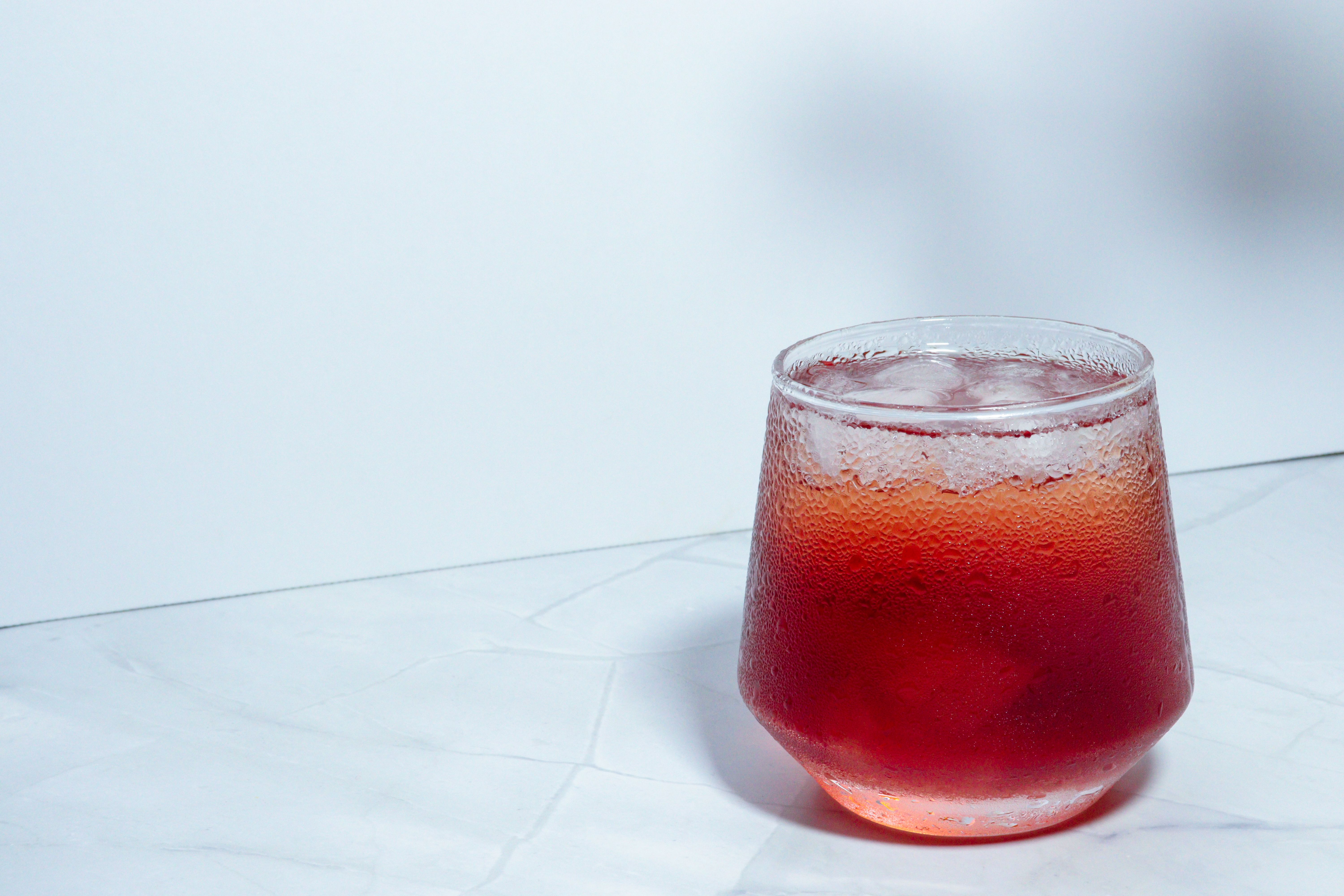 Short Glass of Cold Red Drink with Ice Cubes · Free Stock Photo