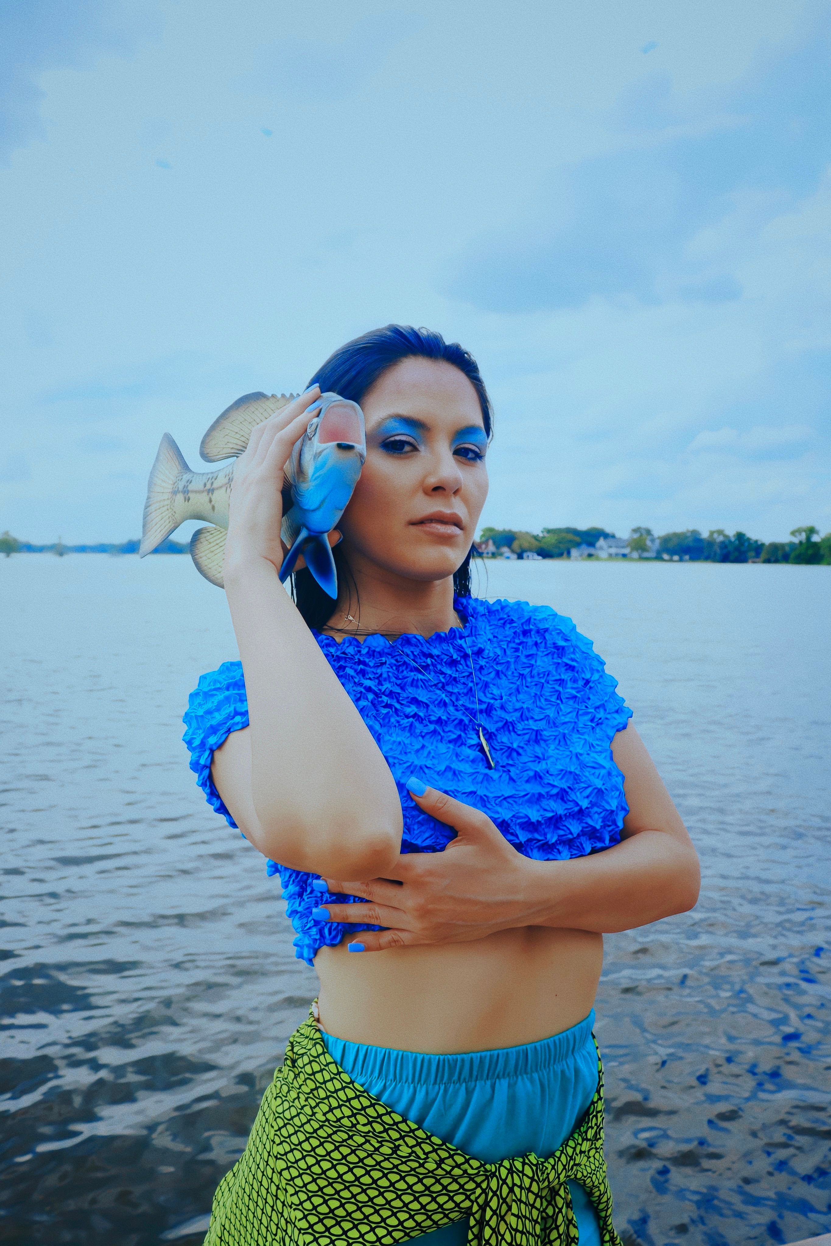 Woman Posing with Toy Fish and Water behind · Free Stock Photo