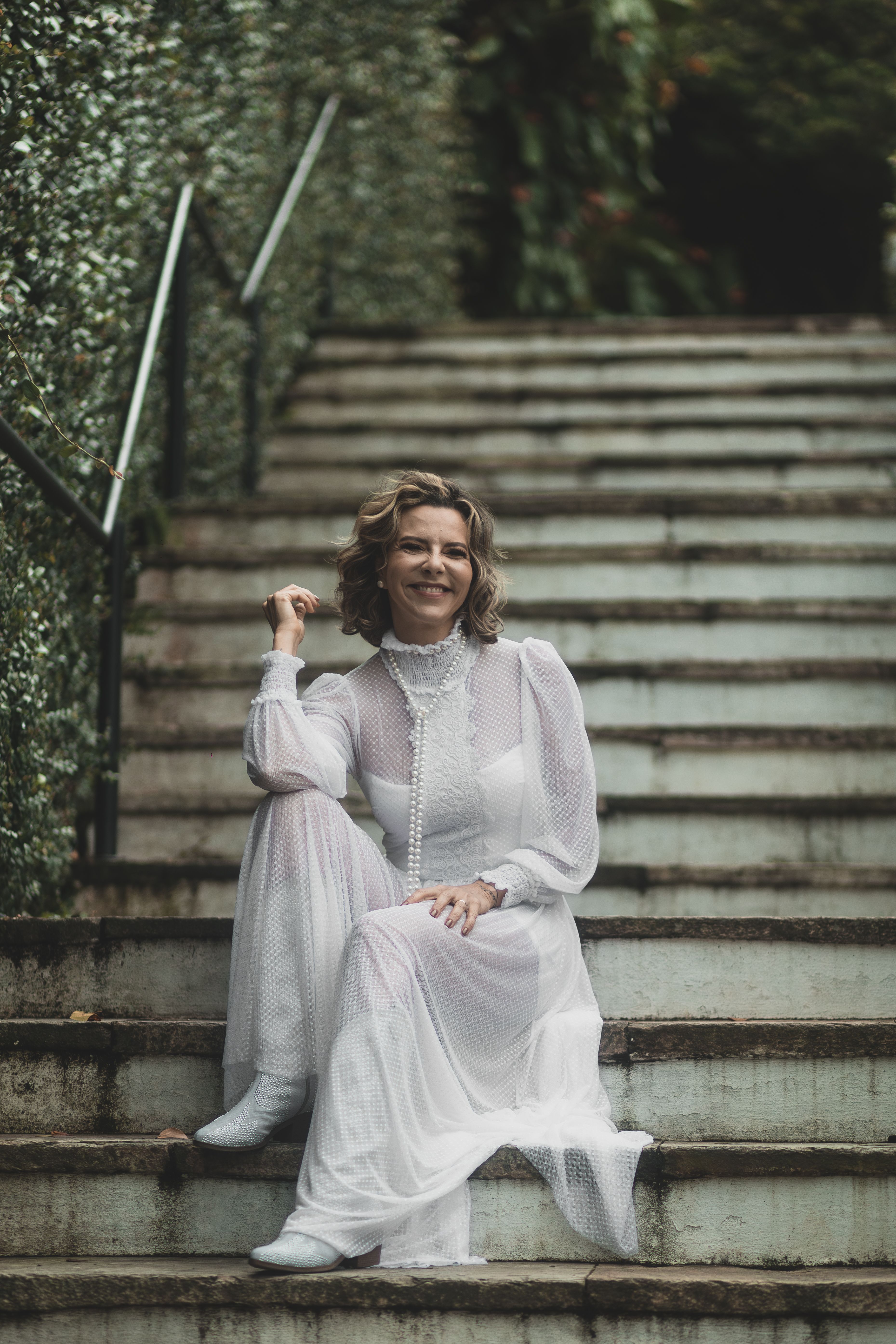 Smiling Bride Sitting on Stairs · Free Stock Photo