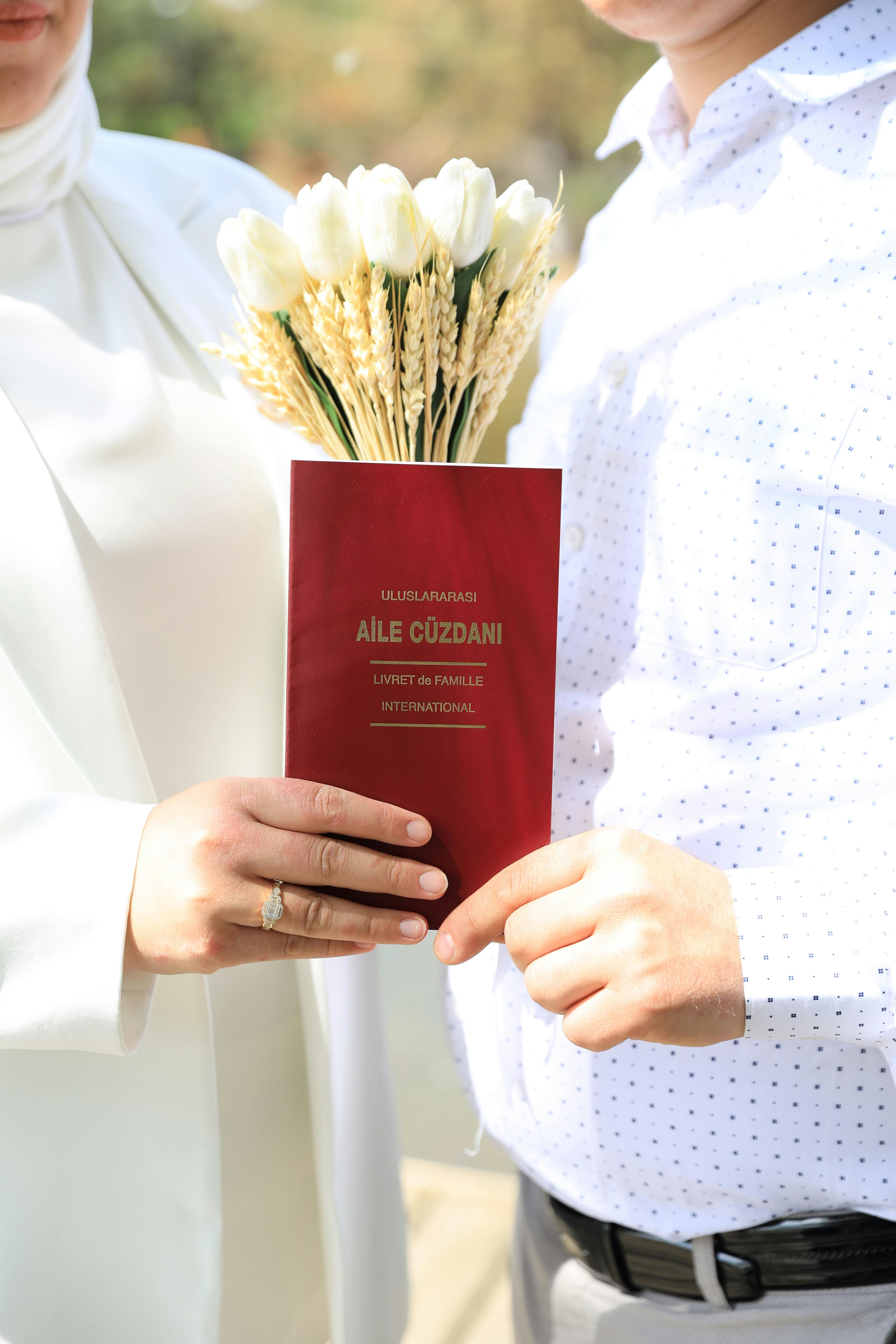 Bride and Groom Holding a Family Registry Booklet · Free Stock Photo