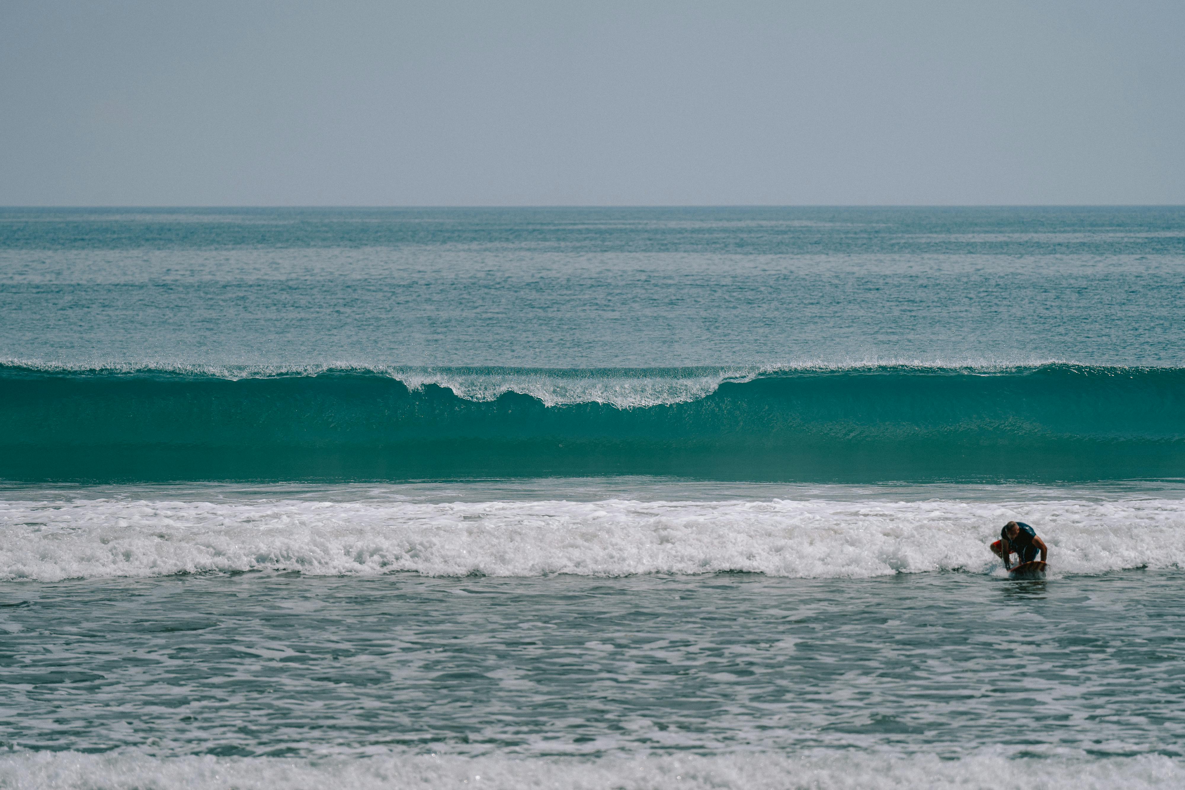 Man Surfing with Arms Raised · Free Stock Photo