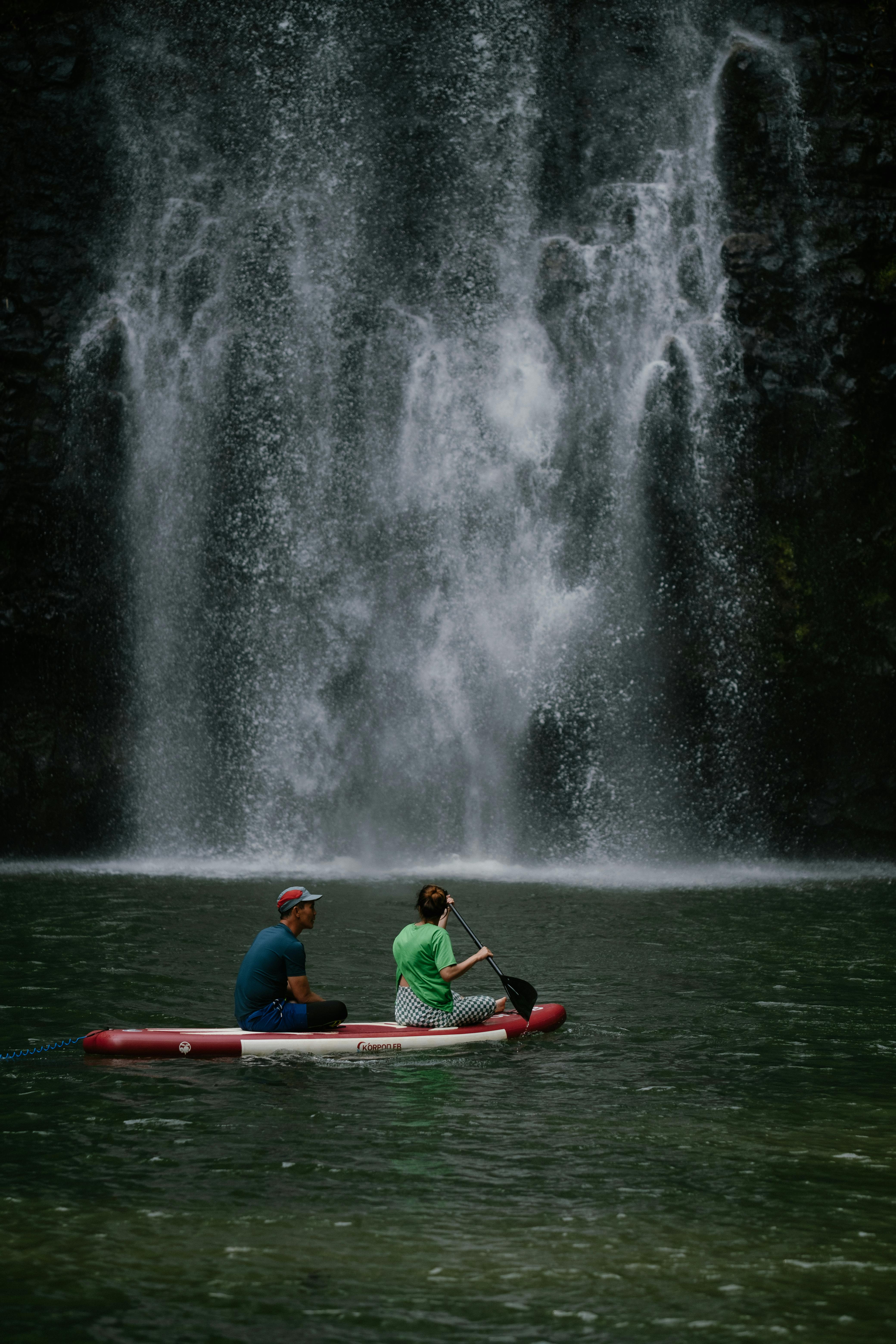 Woman and Man Canoeing near Waterfall · Free Stock Photo