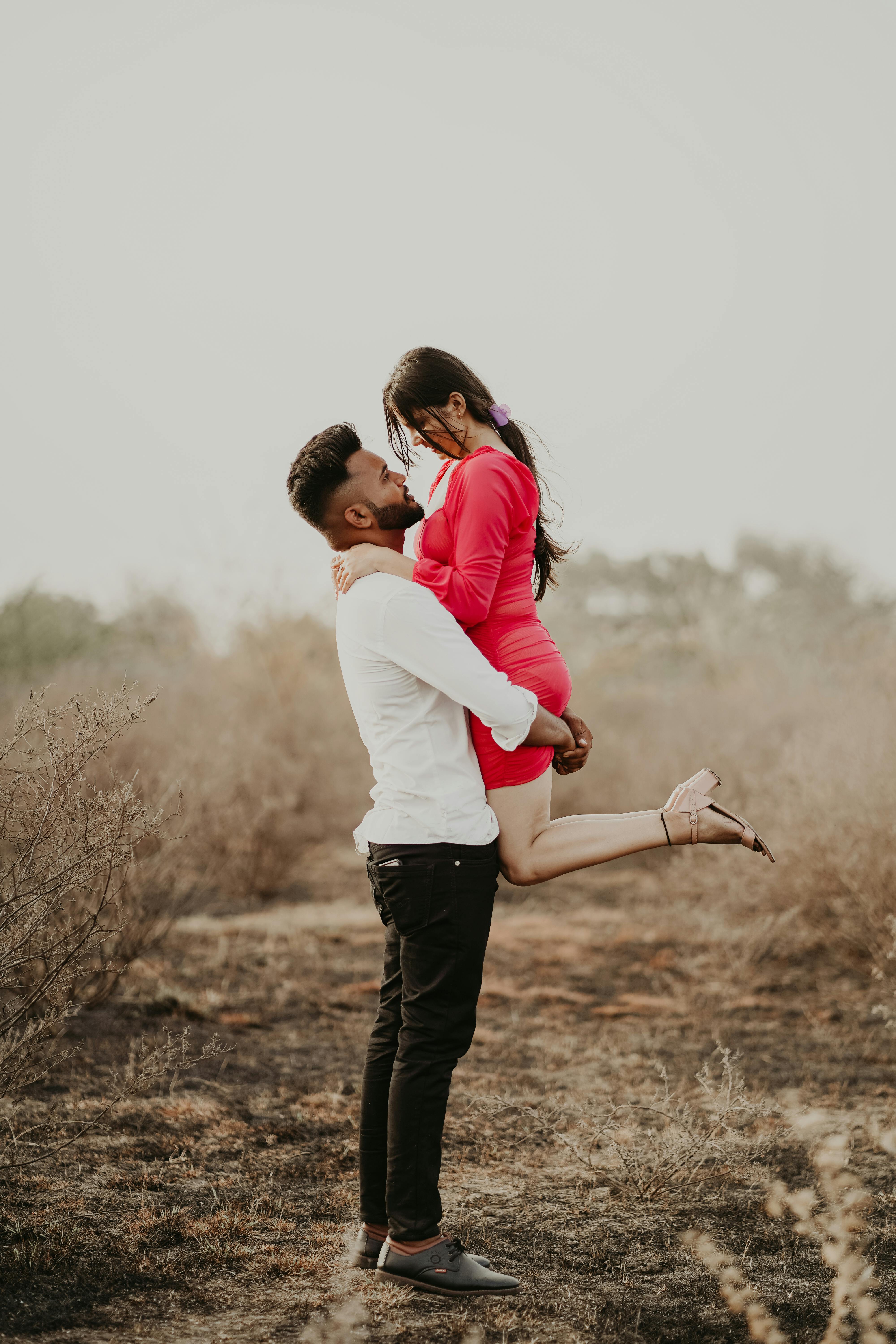 Man Picking Up His Girlfriend on a Field · Free Stock Photo
