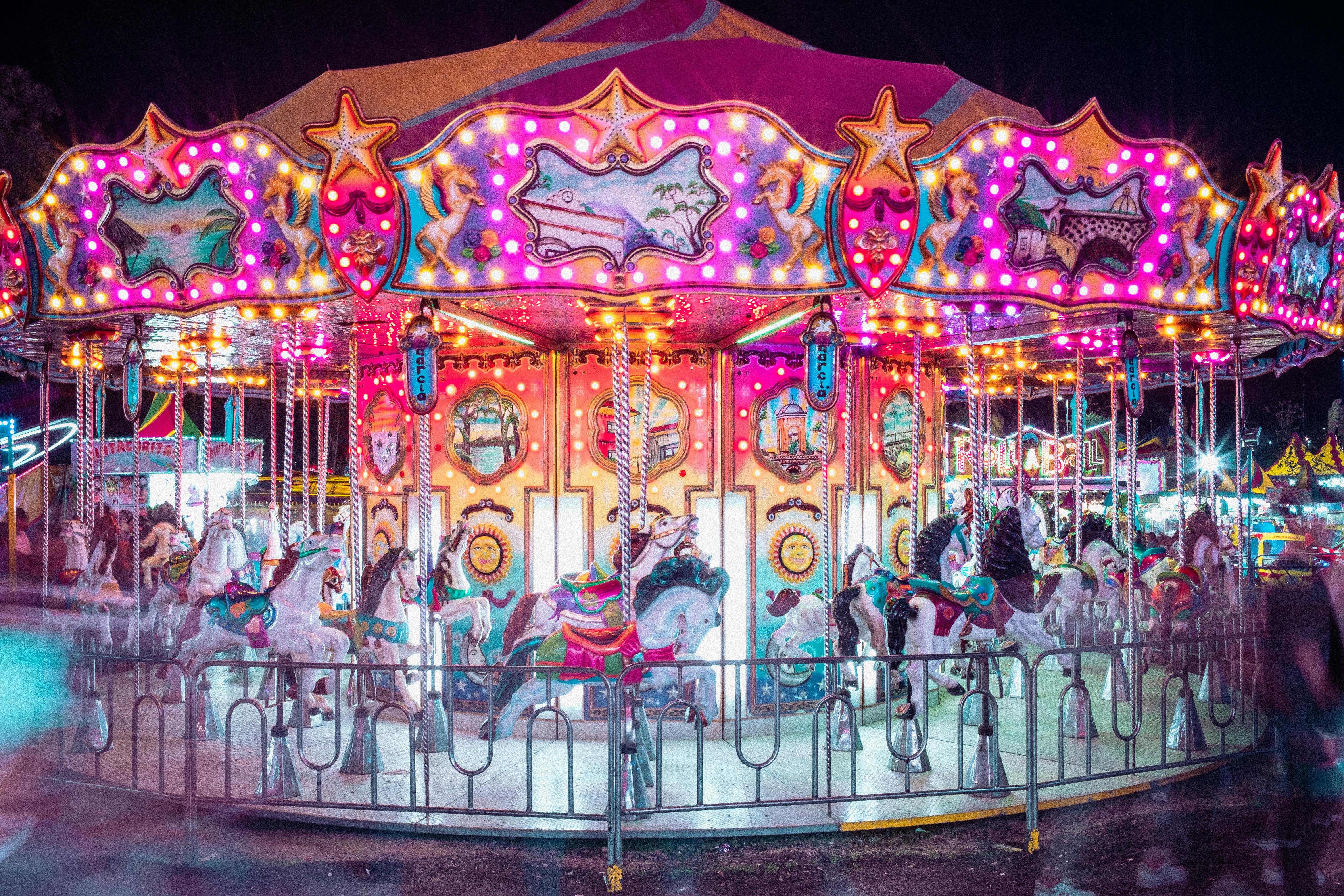 Illuminated carousel in amusement park in evening · Free Stock Photo