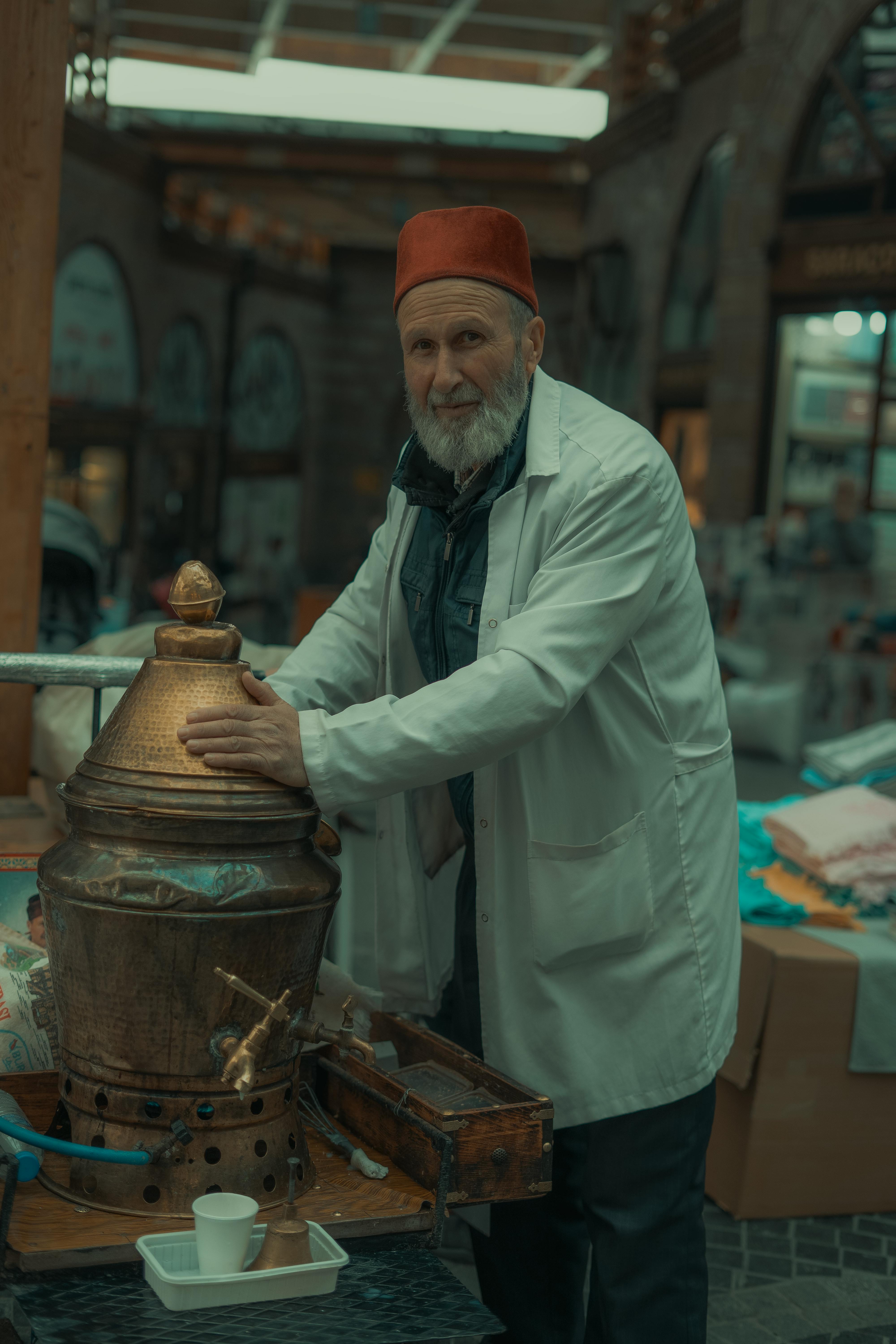 Man in a Turkish Fez Boiling Water in a Samovar · Free Stock Photo