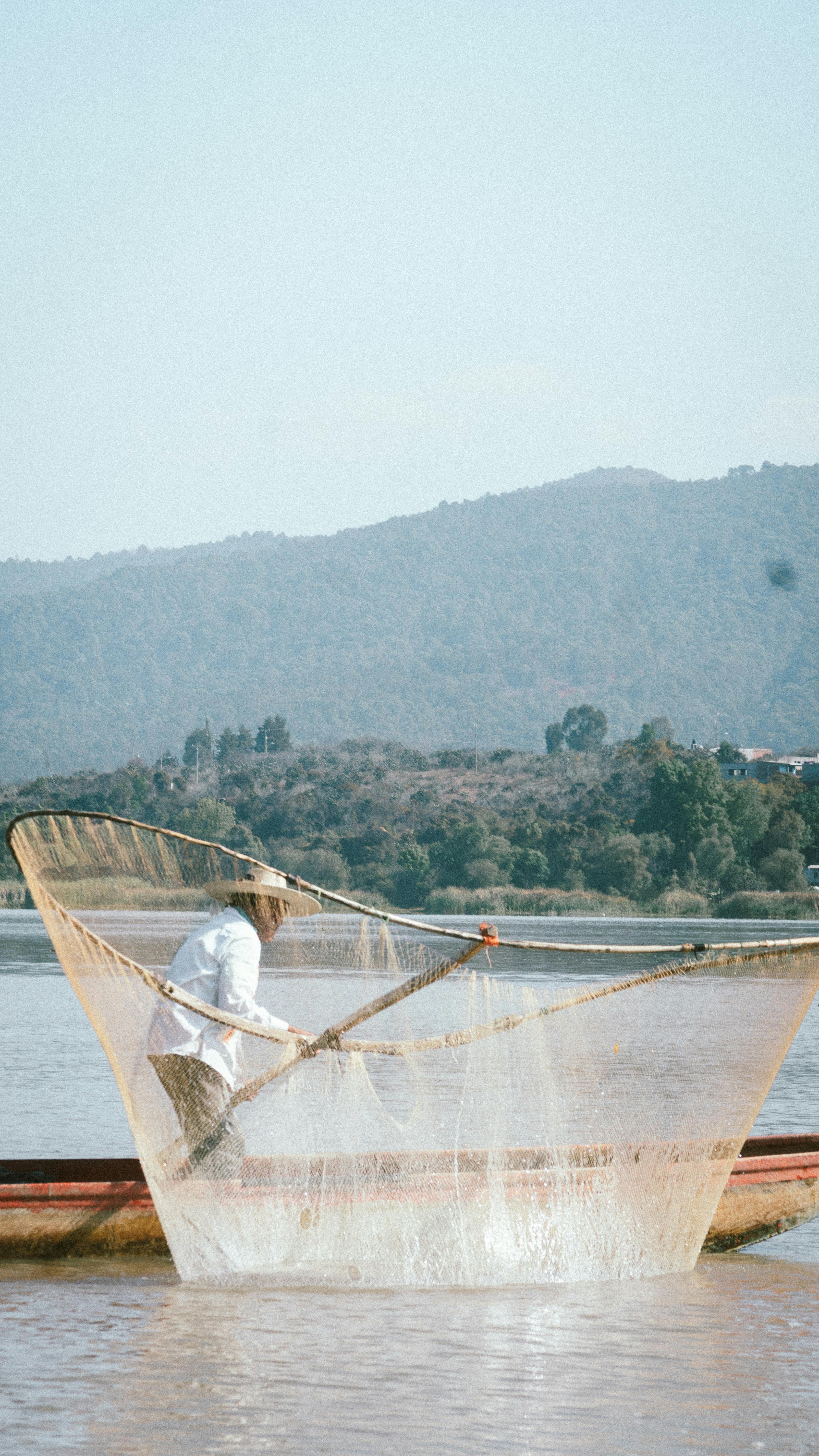 Man on a Boat Fishing with a Net · Free Stock Photo