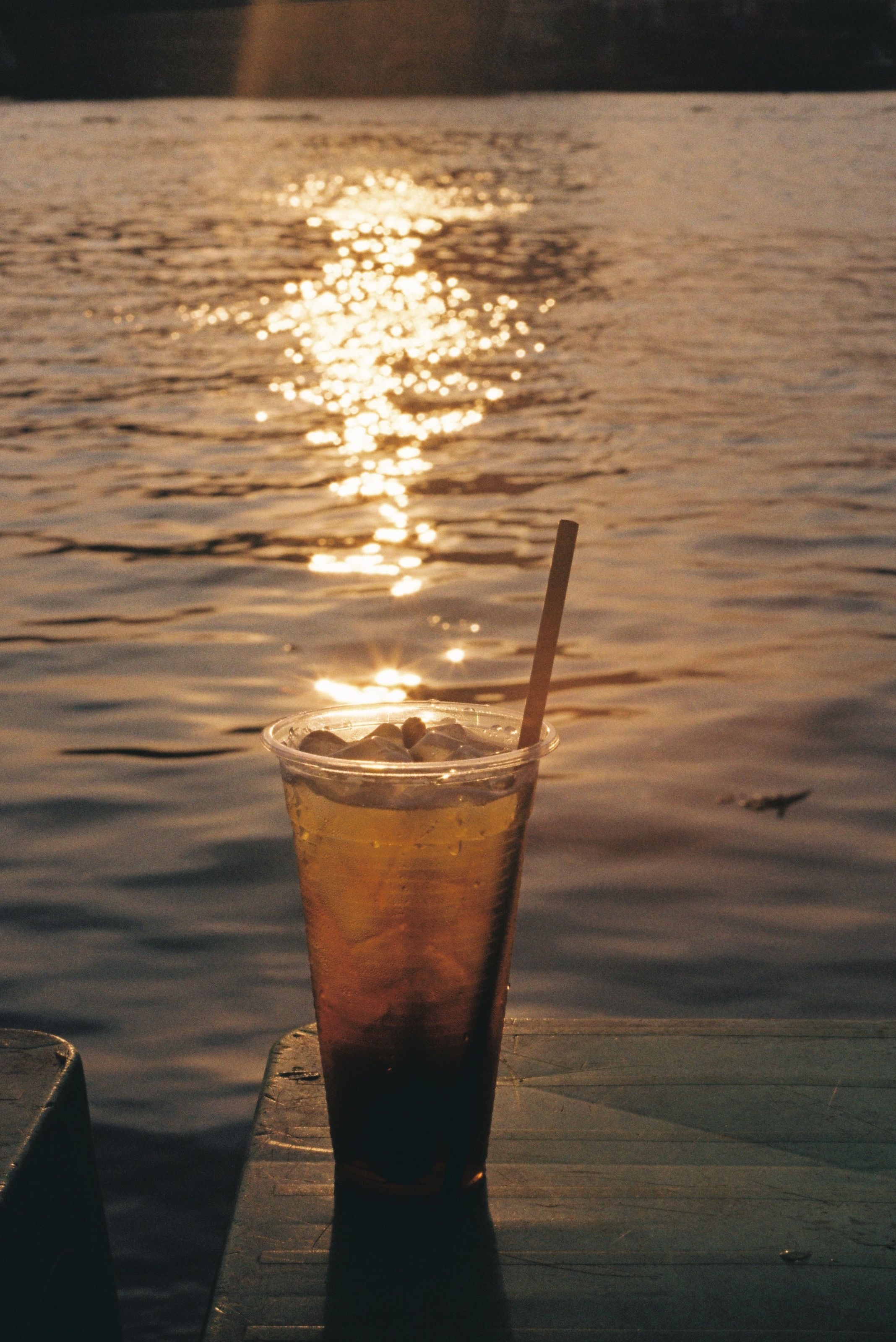 Plastic Cup with Iced Drink Left on Jetty on Lake Shore at Sunset ...