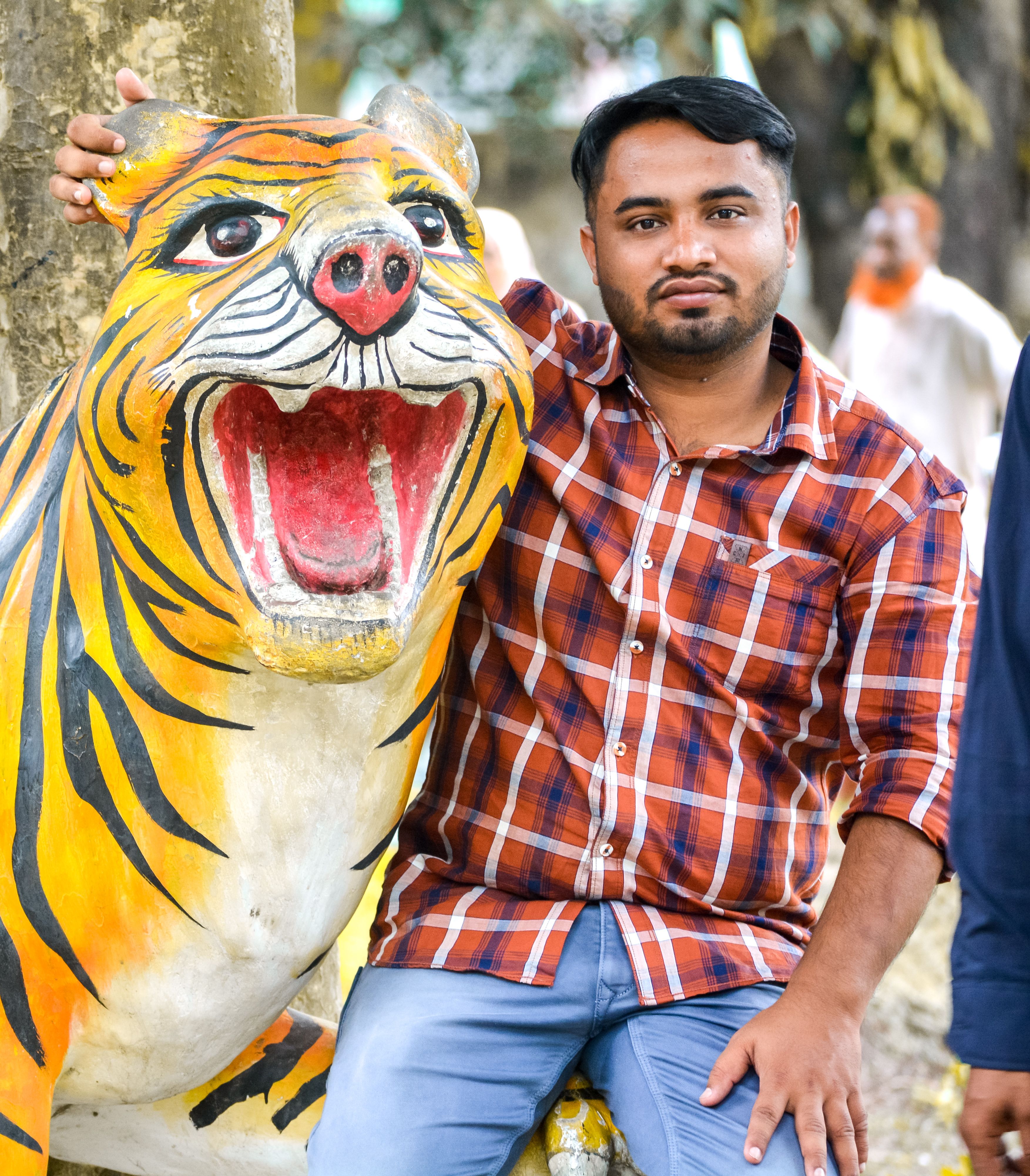 Man Posing with Colorful Tiger Statue · Free Stock Photo