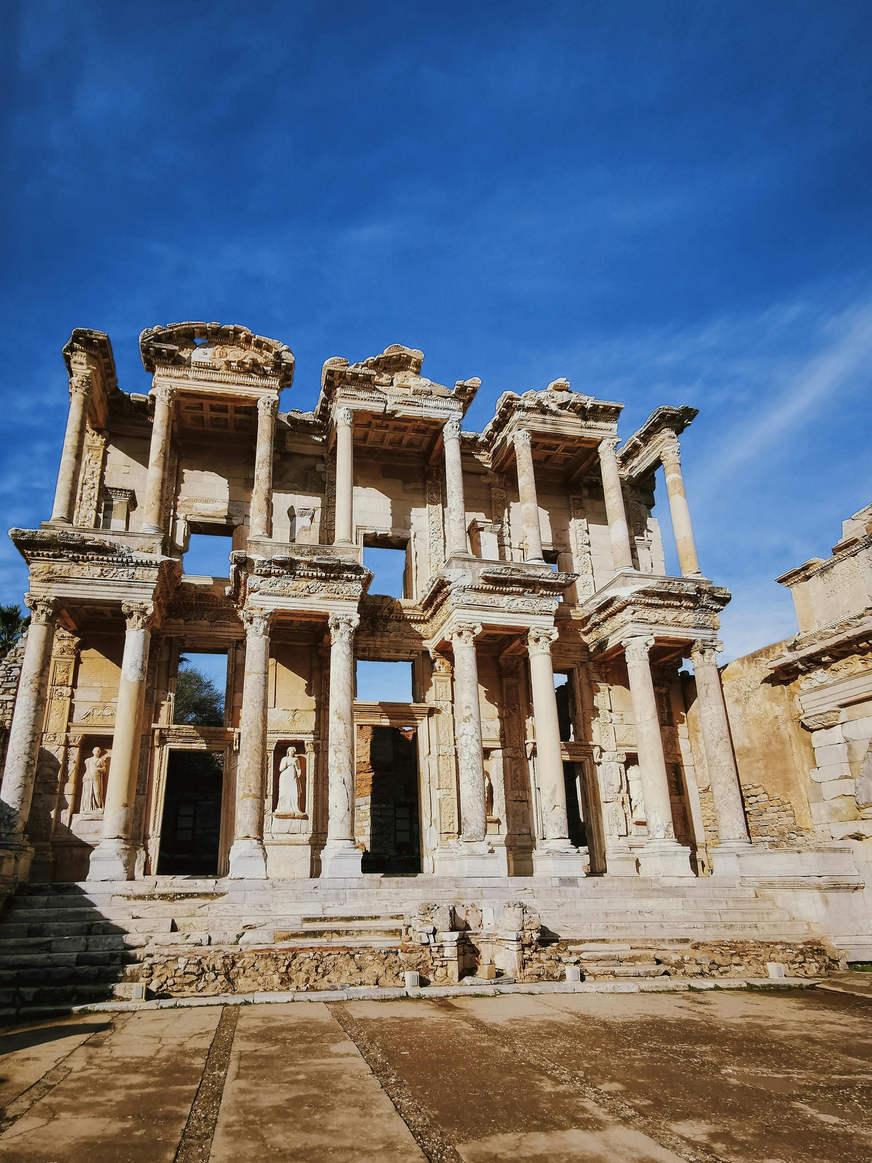 Library of Celsus with sculpture and damaged wall · Free Stock Photo