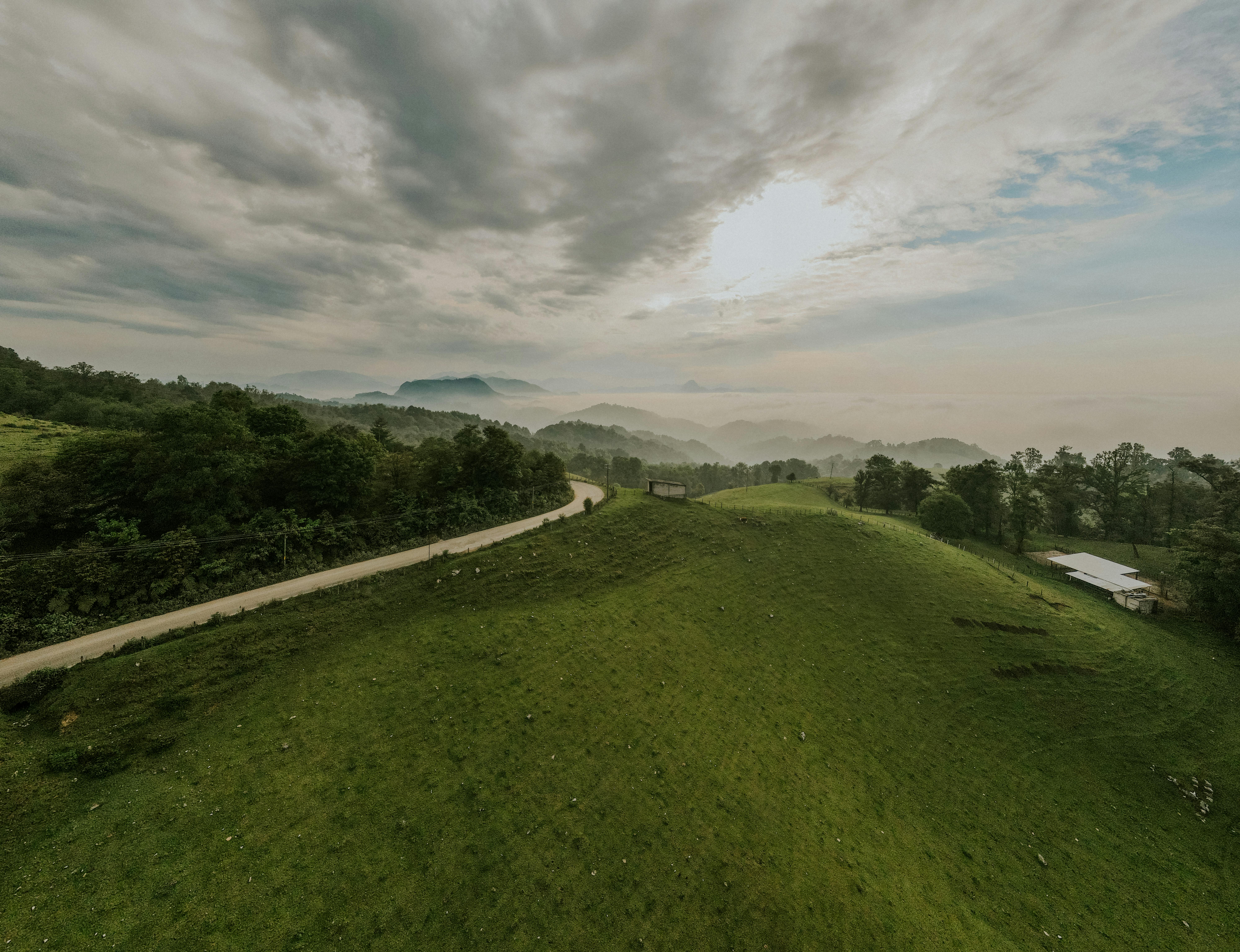 Scenic Rural Landscape with Curved Road · Free Stock Photo
