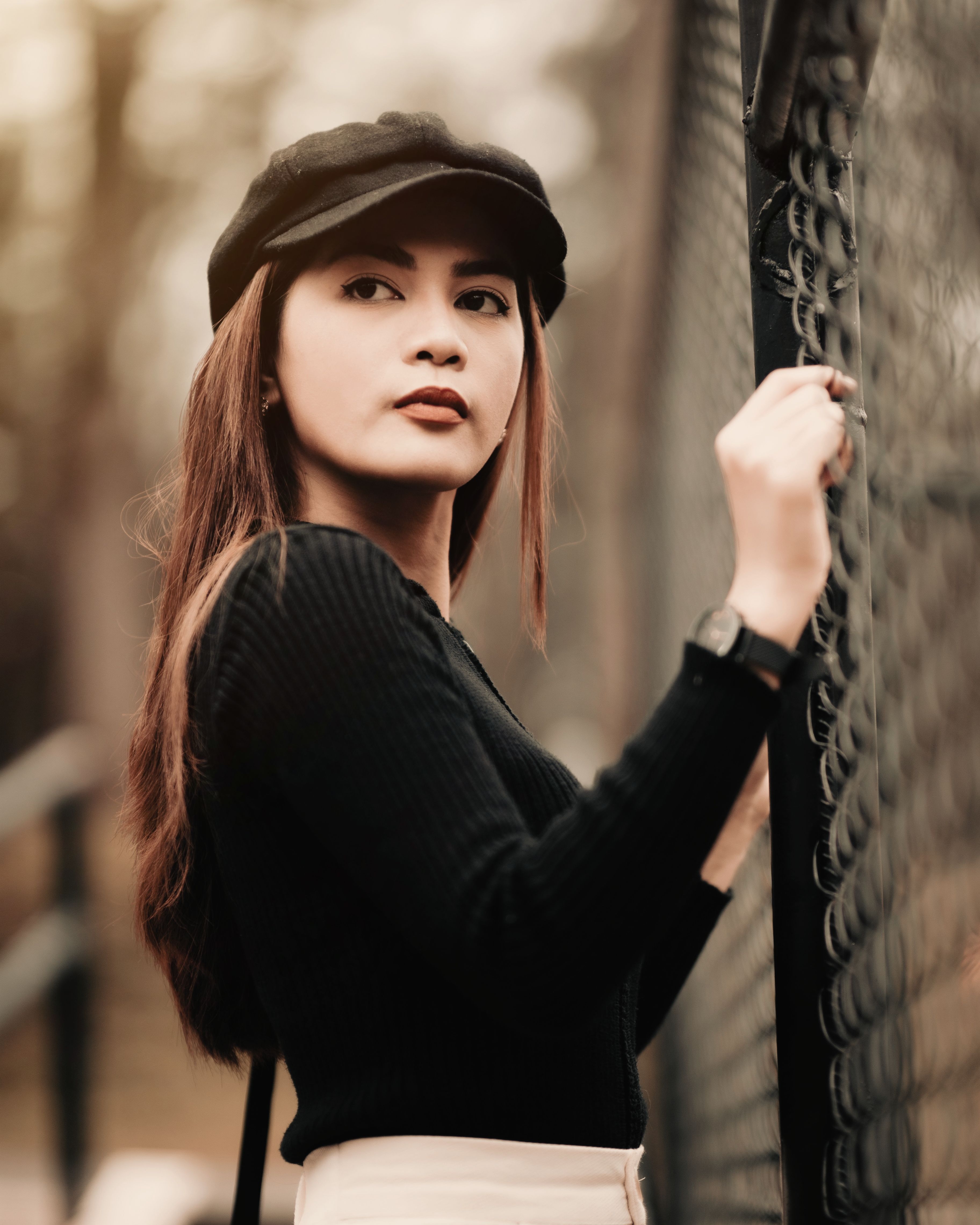 Woman in Flat Cap Holds Netting Fence · Free Stock Photo