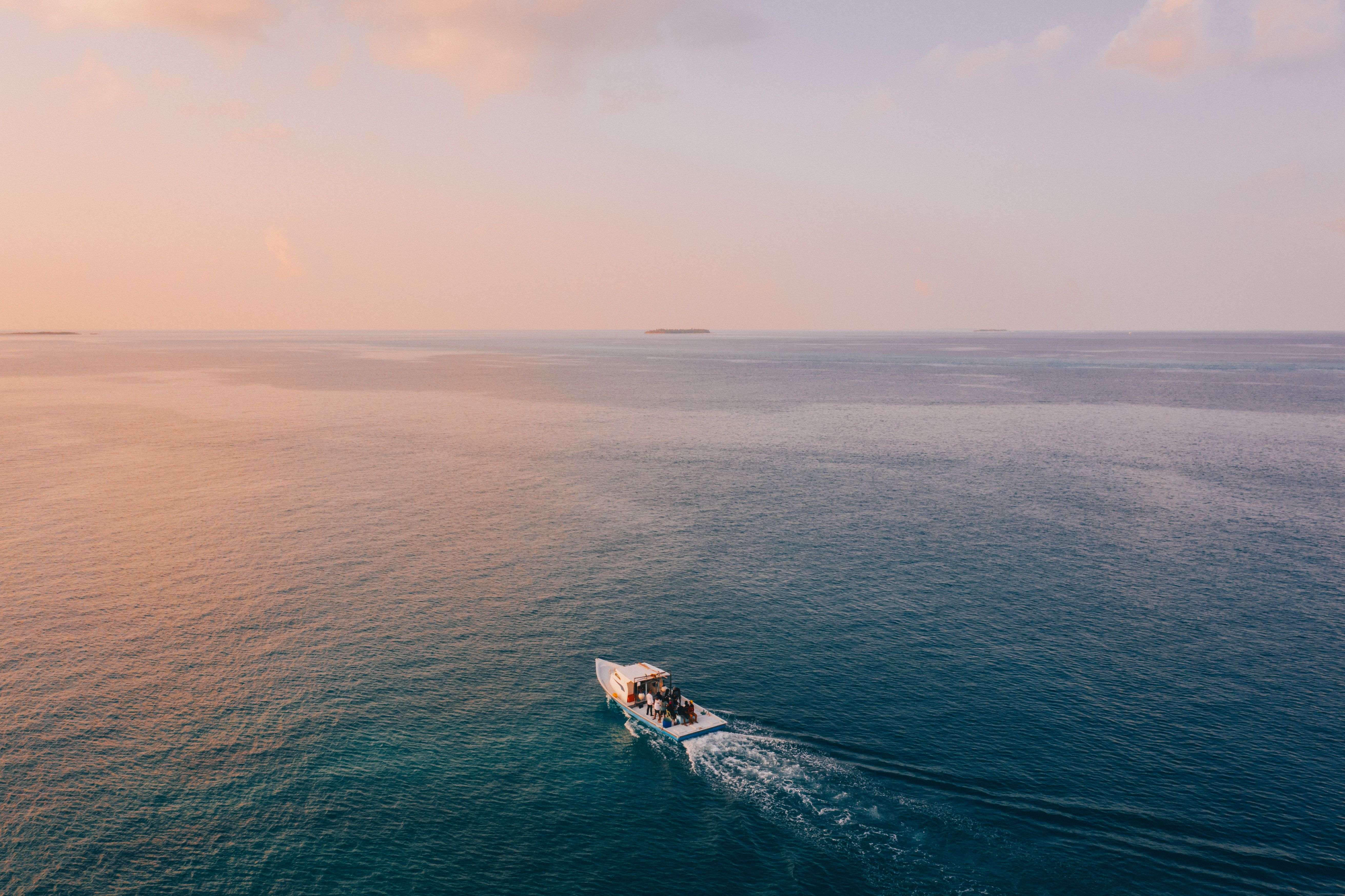 Aerial View of a Boat with Passengers on the Sea at Sunset · Free Stock ...