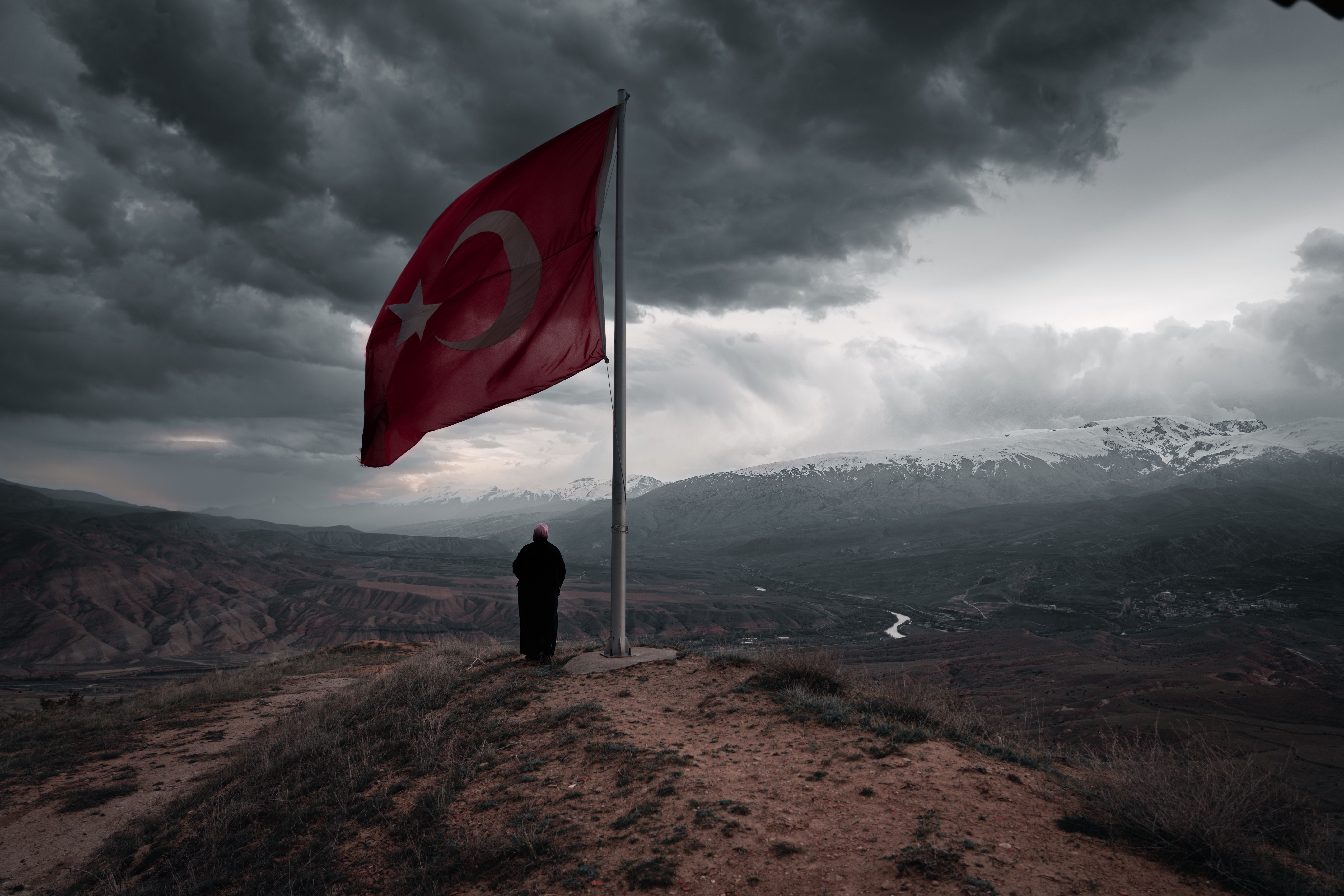 Man Standing under a Turkish Flag on a Mountain Peak · Free Stock Photo