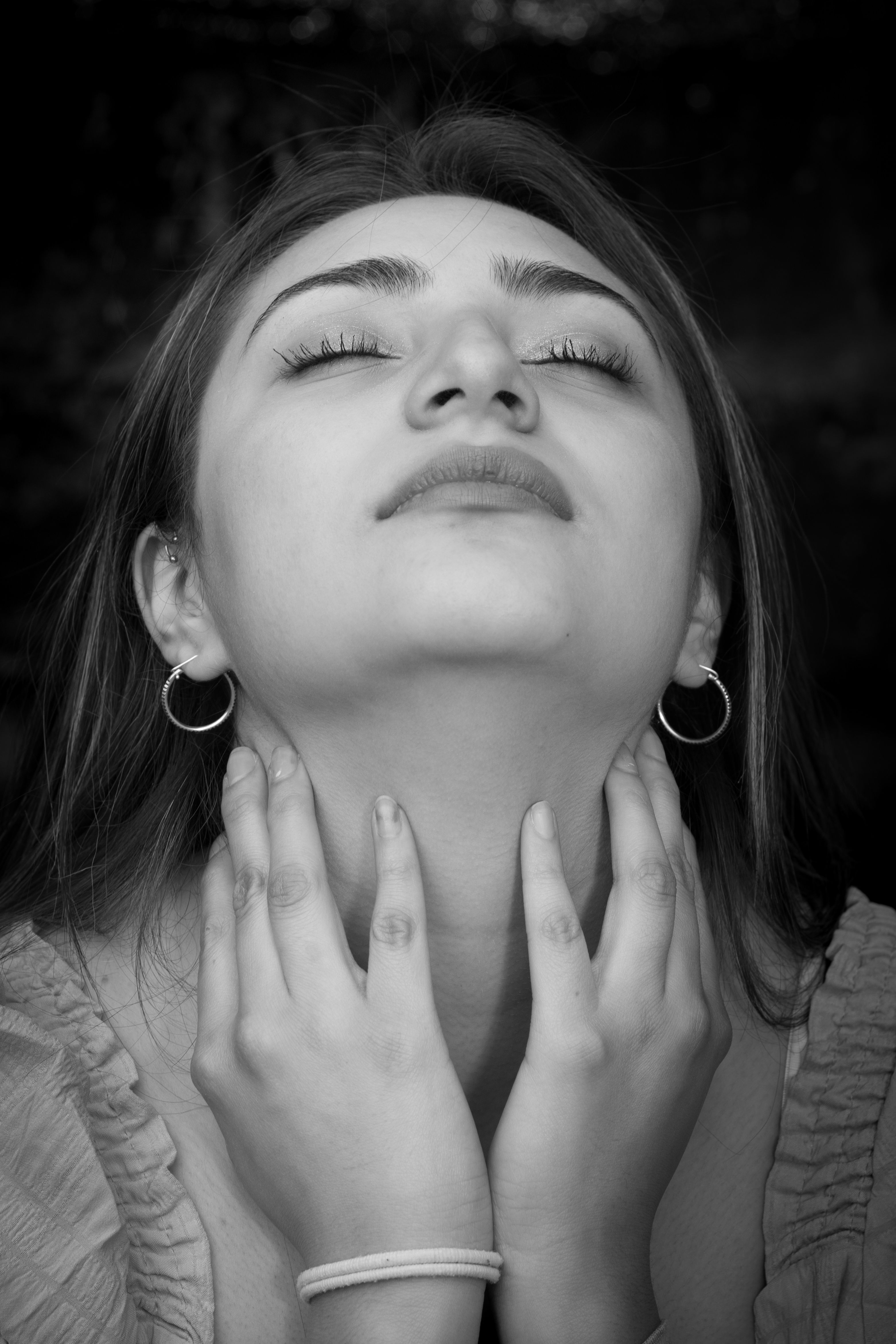 Woman with Hands on Neck in Black and White · Free Stock Photo